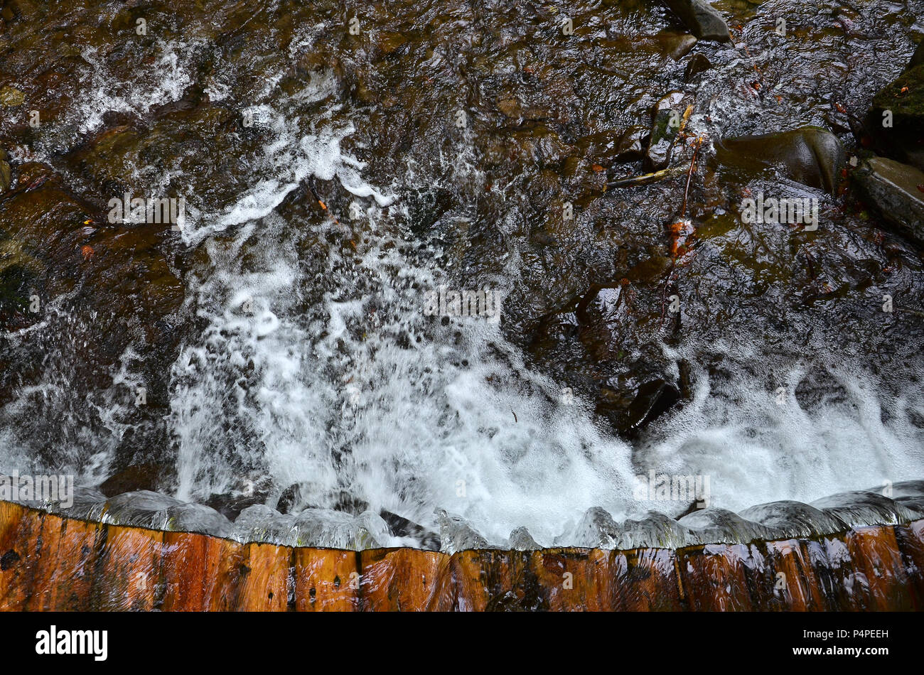 Handmade wooden water drains from small treated beams. A beautiful ...