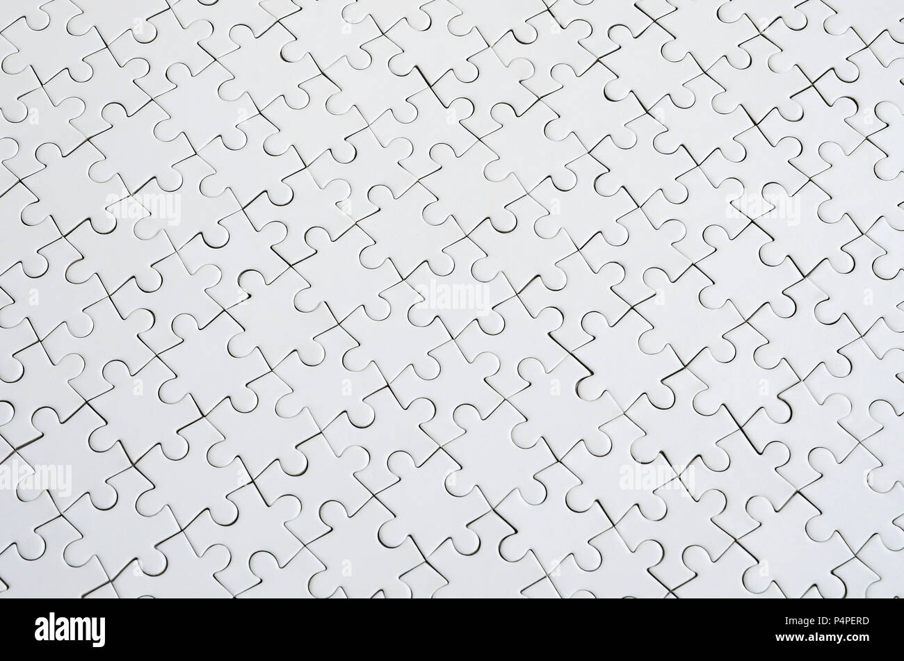 Close up texture of a white jigsaw puzzle in assembled condition. Top ...