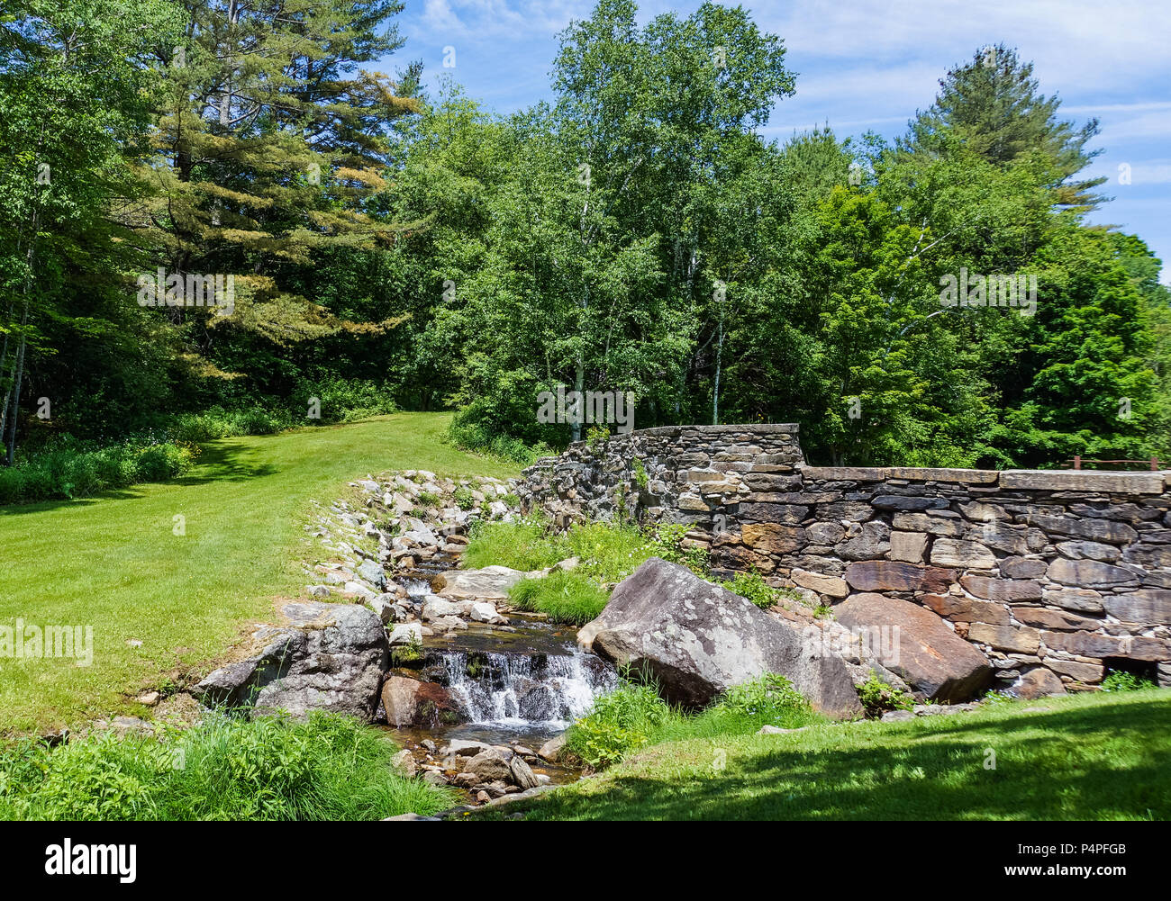 brook falling down stones along old stone wall in country scene Stock ...