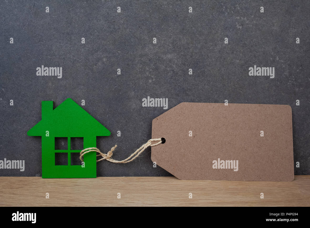 Small house with label over a wooden background Stock Photo - Alamy