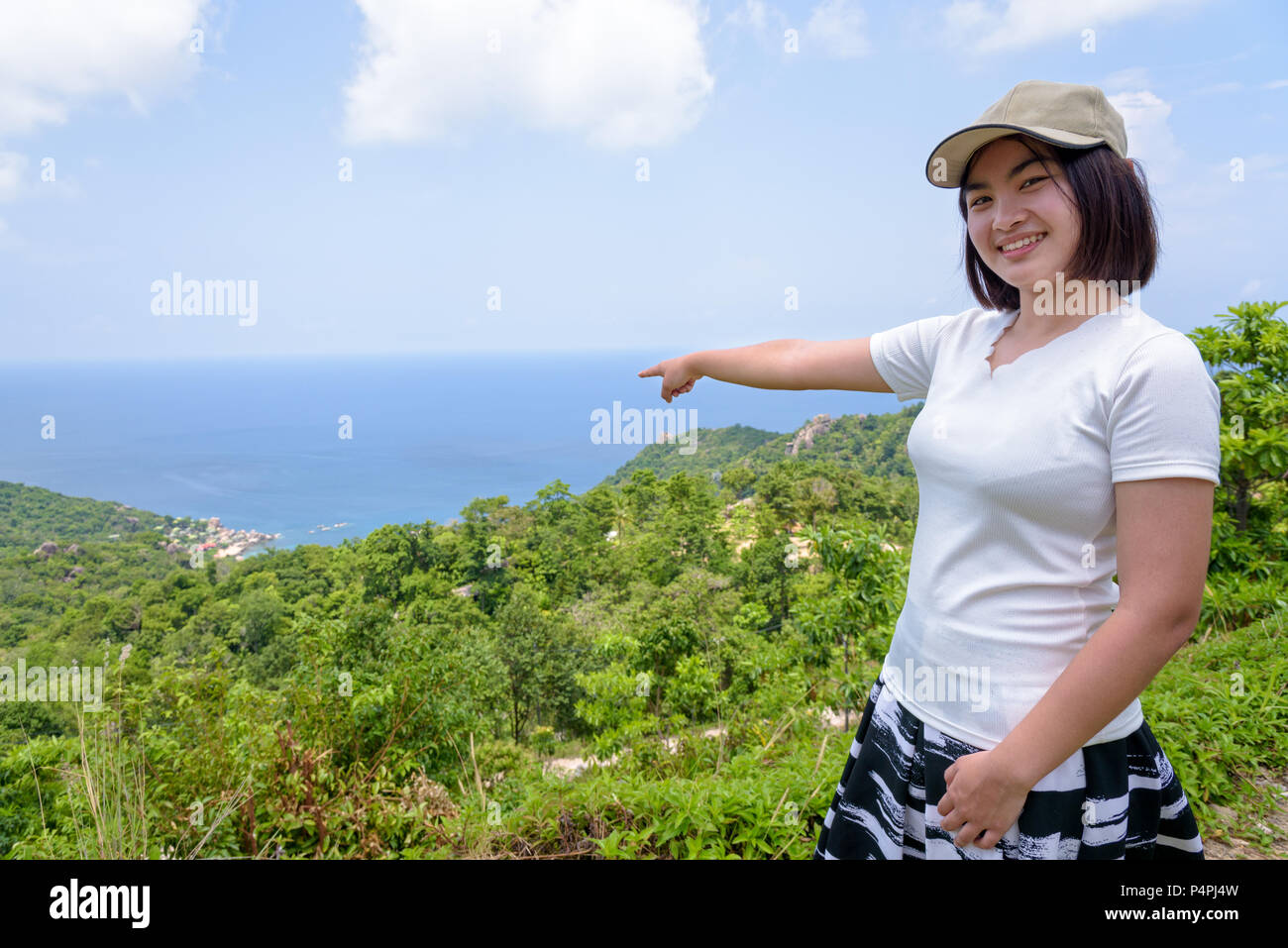 Women tourists raise hand and pointing the finger at the sea on high ...