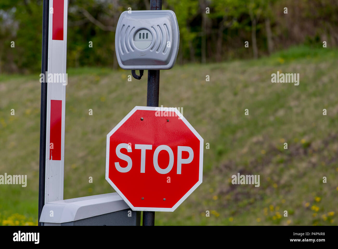 Barrier on a road. The sign "stop" and remote control receiver. Concept ...