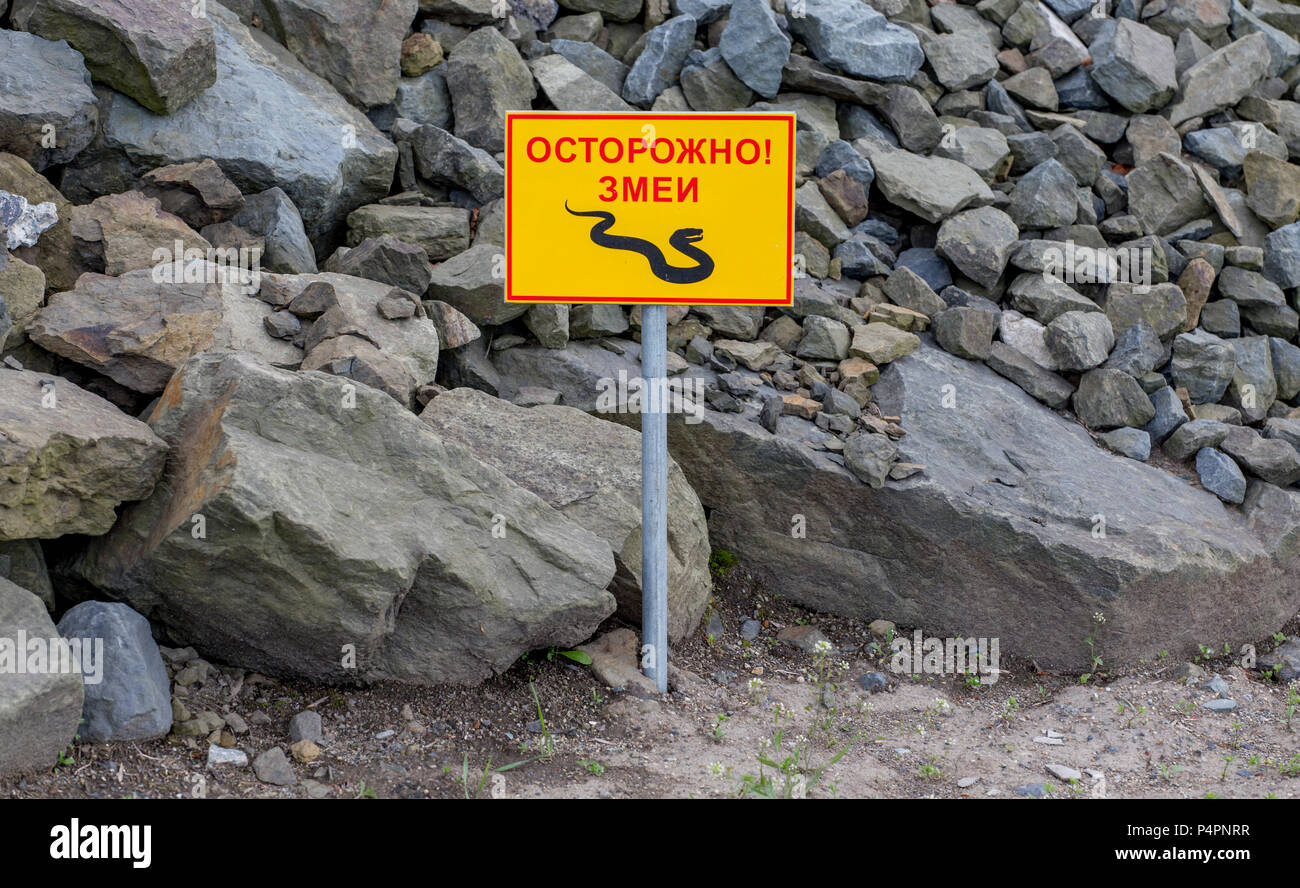 Warning sign "Caution: snakes" in a Russian. Warning sign in place ...