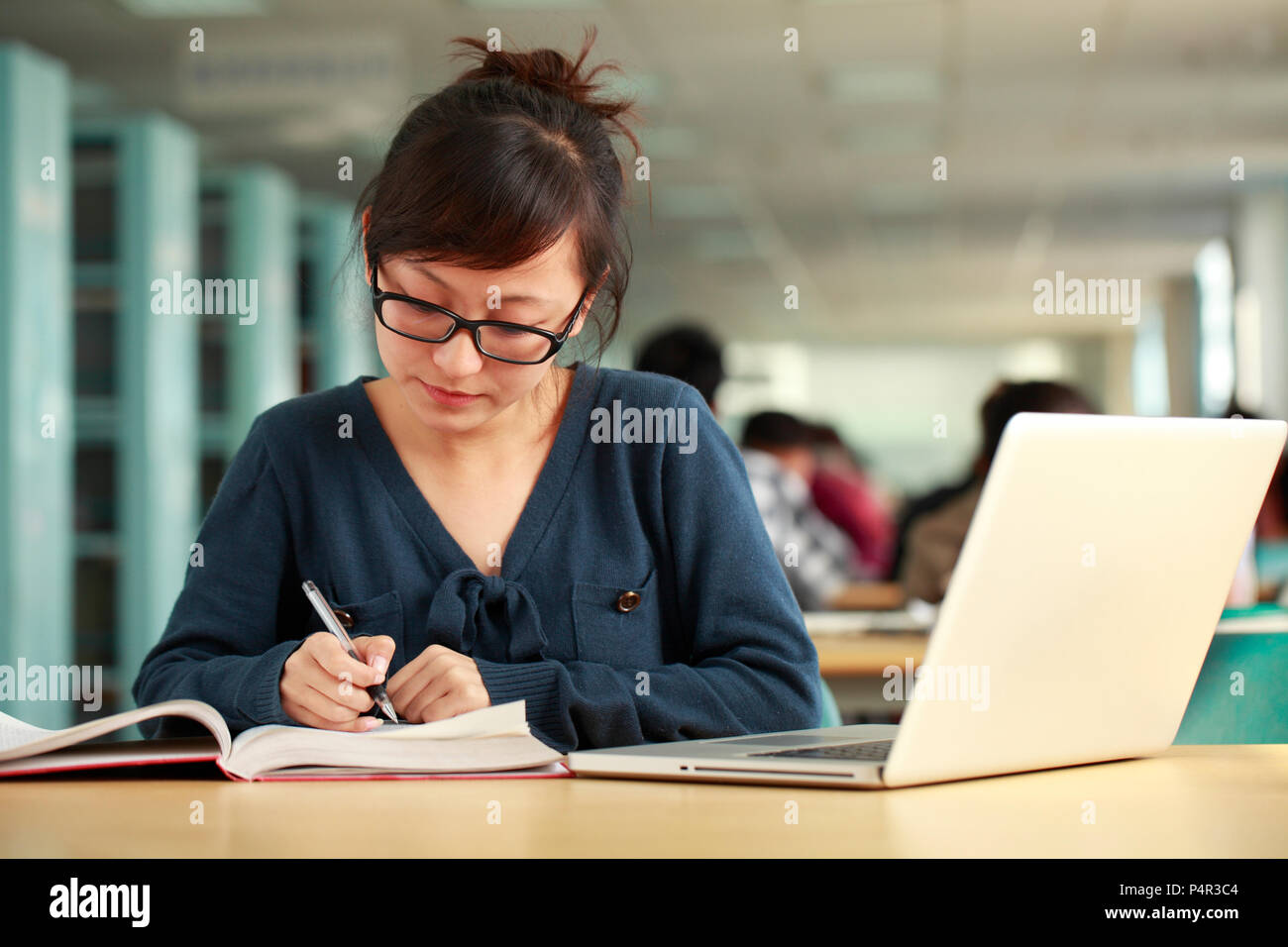 Asian teen girl writing library hi-res stock photography and images - Alamy