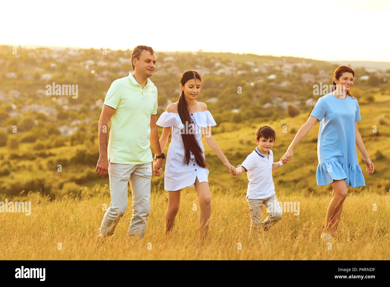 Happy family is having fun around the field Stock Photo - Alamy