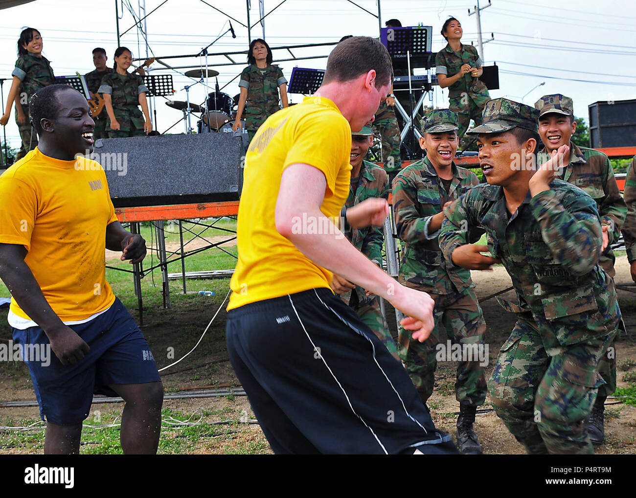 U.S. Sailors and Royal Thai marines dance as members of the Royal Thai ...