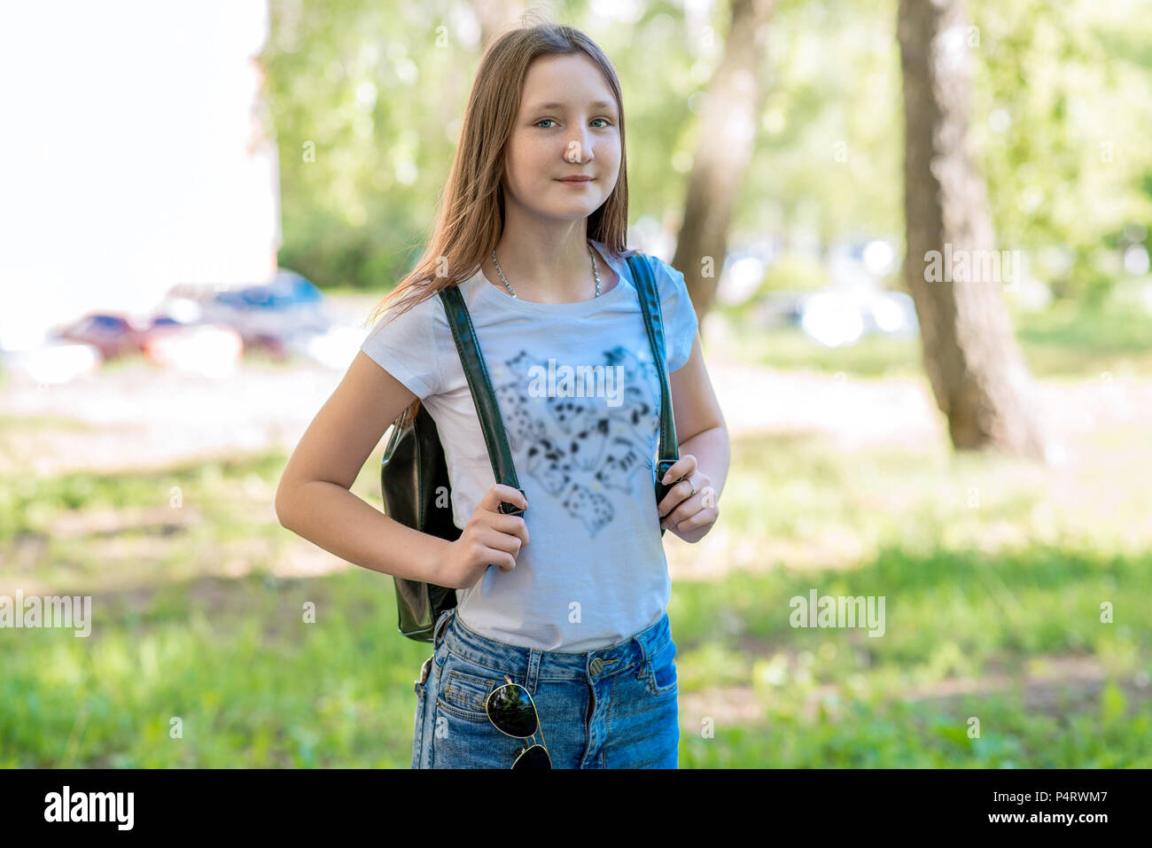 Little girl schoolgirl. In the summer in park. Poses on the camera ...
