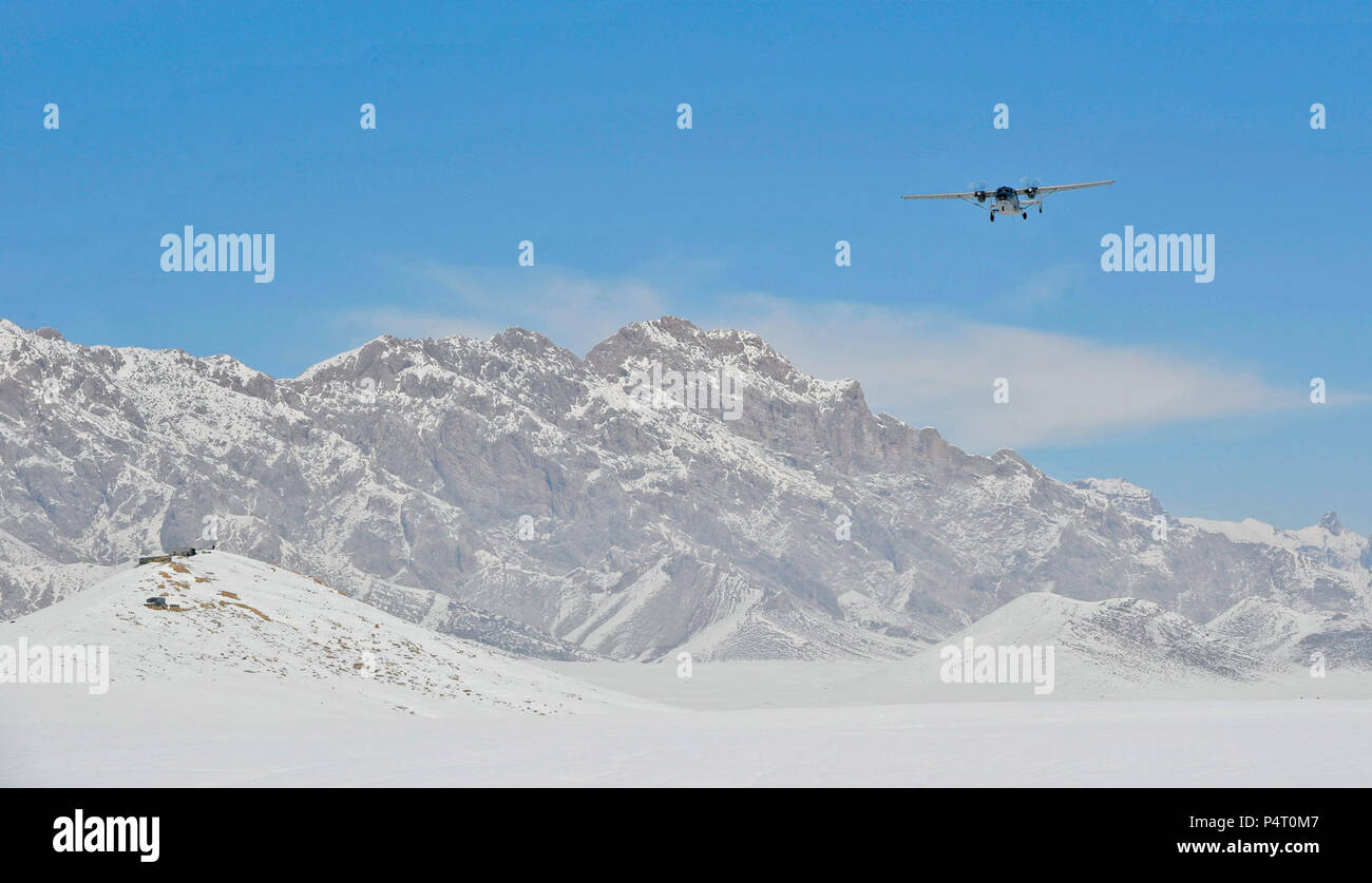 An M-28 Trucker aircraft flies past the Spin Ghar Mountains on approach ...