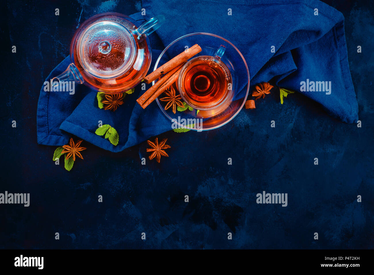 Black tea in a glass cup and a tiny teapot with lemon slices and mint ...