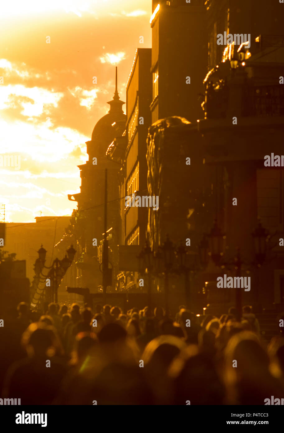 Crowd of people walking down the street at summer evening, beautiful ...