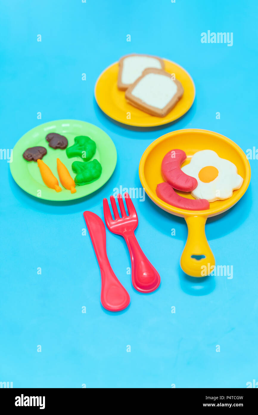 Breakfast model with egg sausage bread and salad on plastic blue table ...