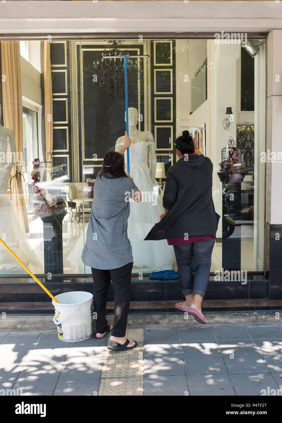 Two women cleaning shop window, Bangkok, Thailand, Asia Stock Photo - Alamy
