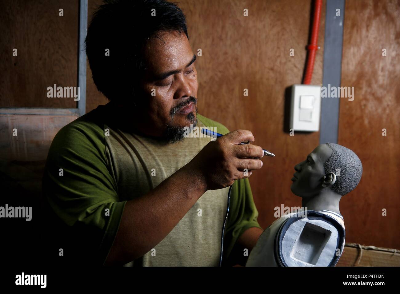 TAYTAY, RIZAL, PHILIPPINES - JUNE 21, 2018: An artist airbrushes colors ...