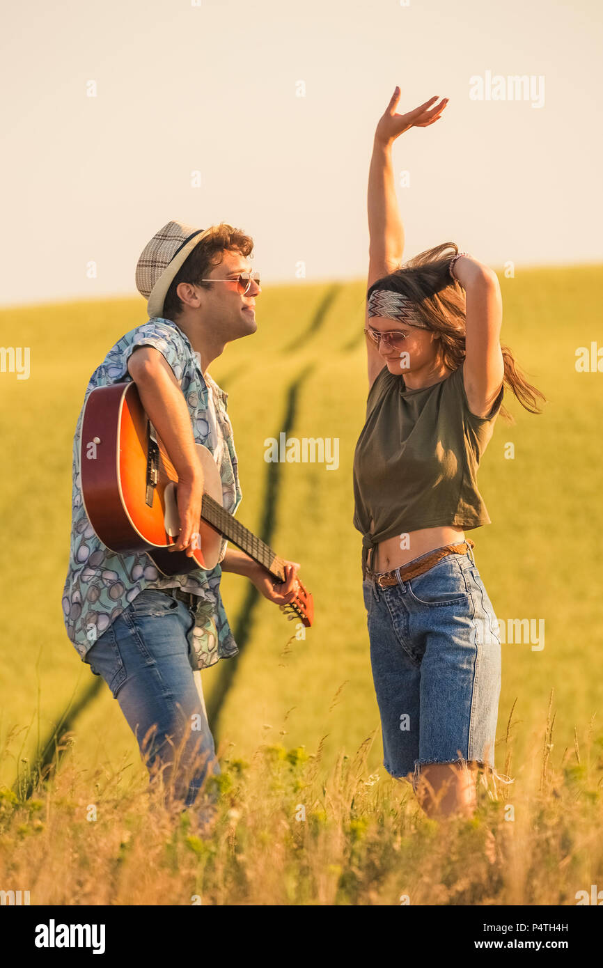 Romantic hipster couple singing their favorite song in nature. Love and ...