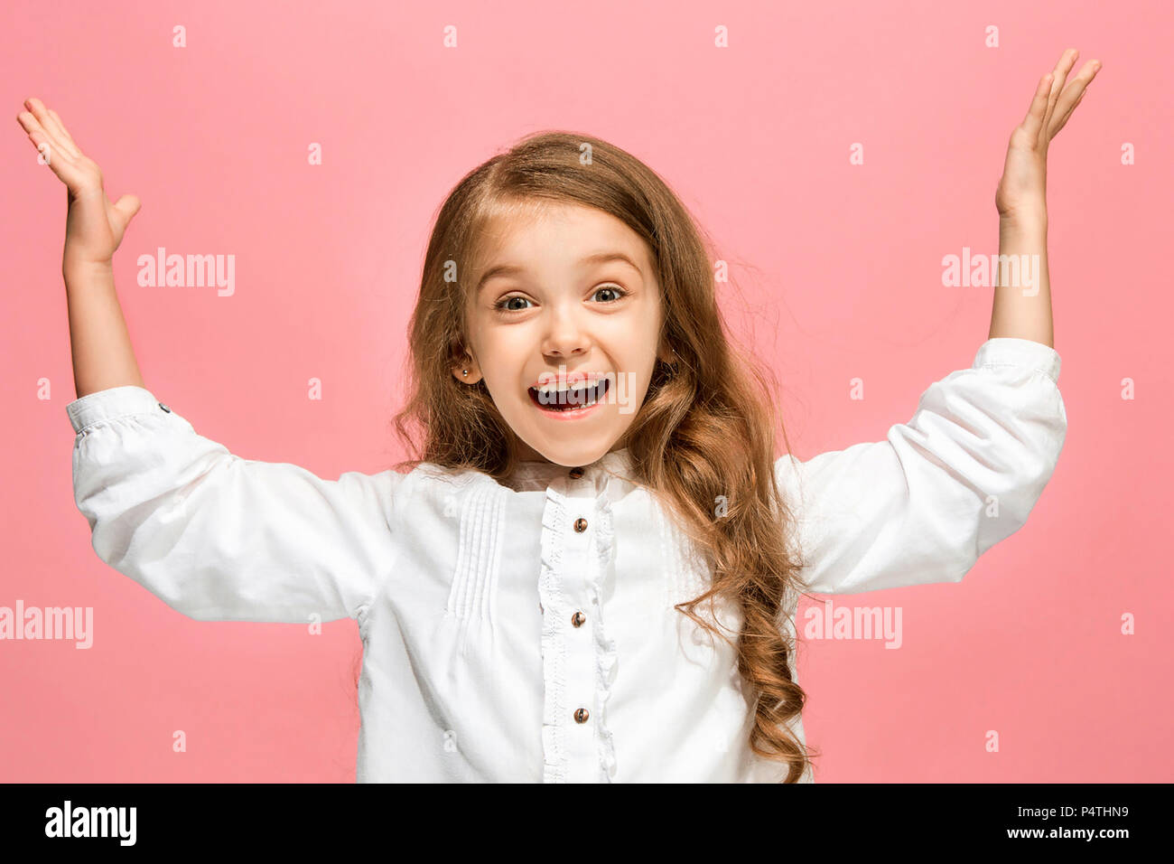 The happy teen girl standing and smiling against pink background Stock ...