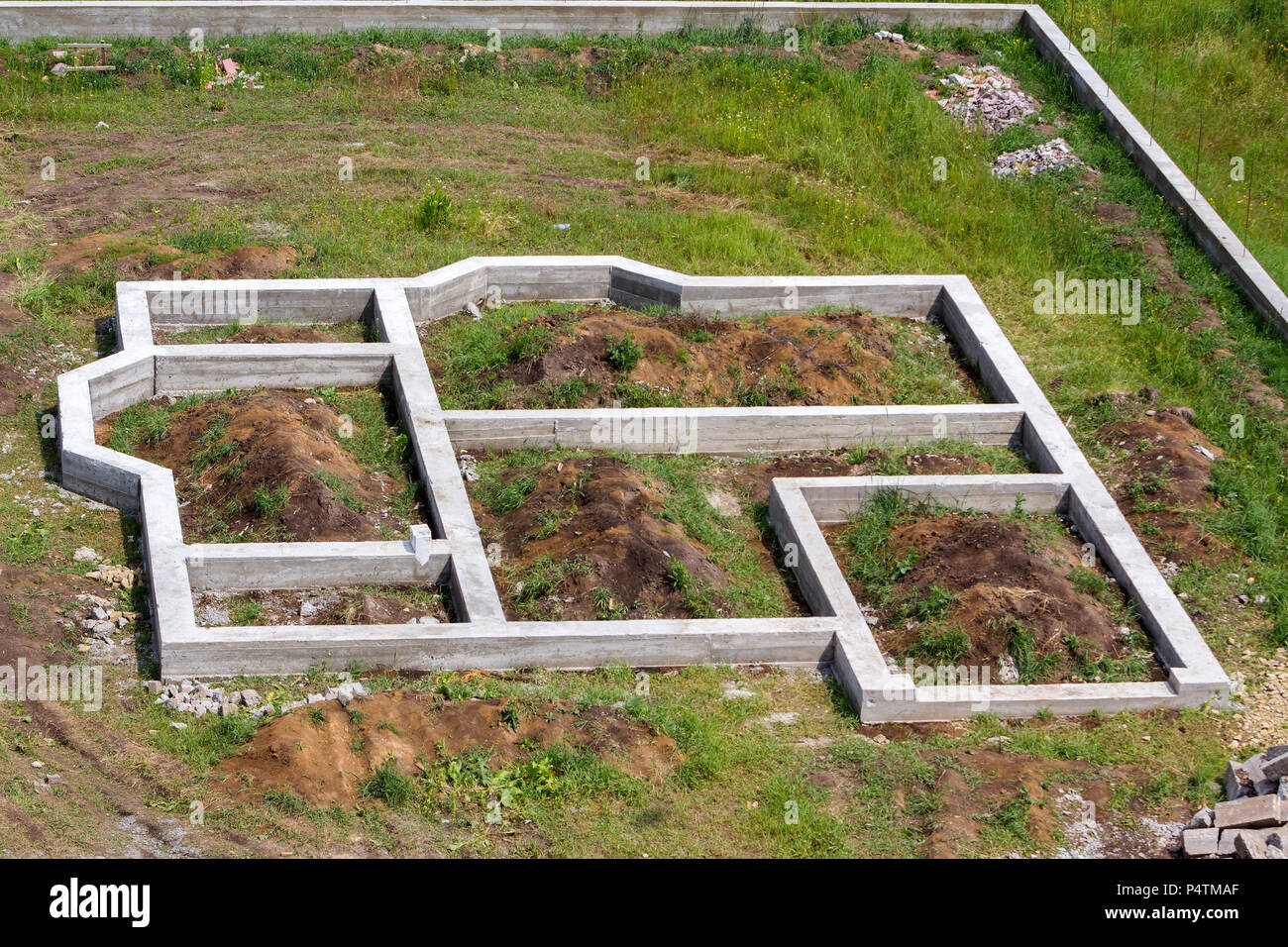 Building site in green field. Trenches dug in ground and filled with ...