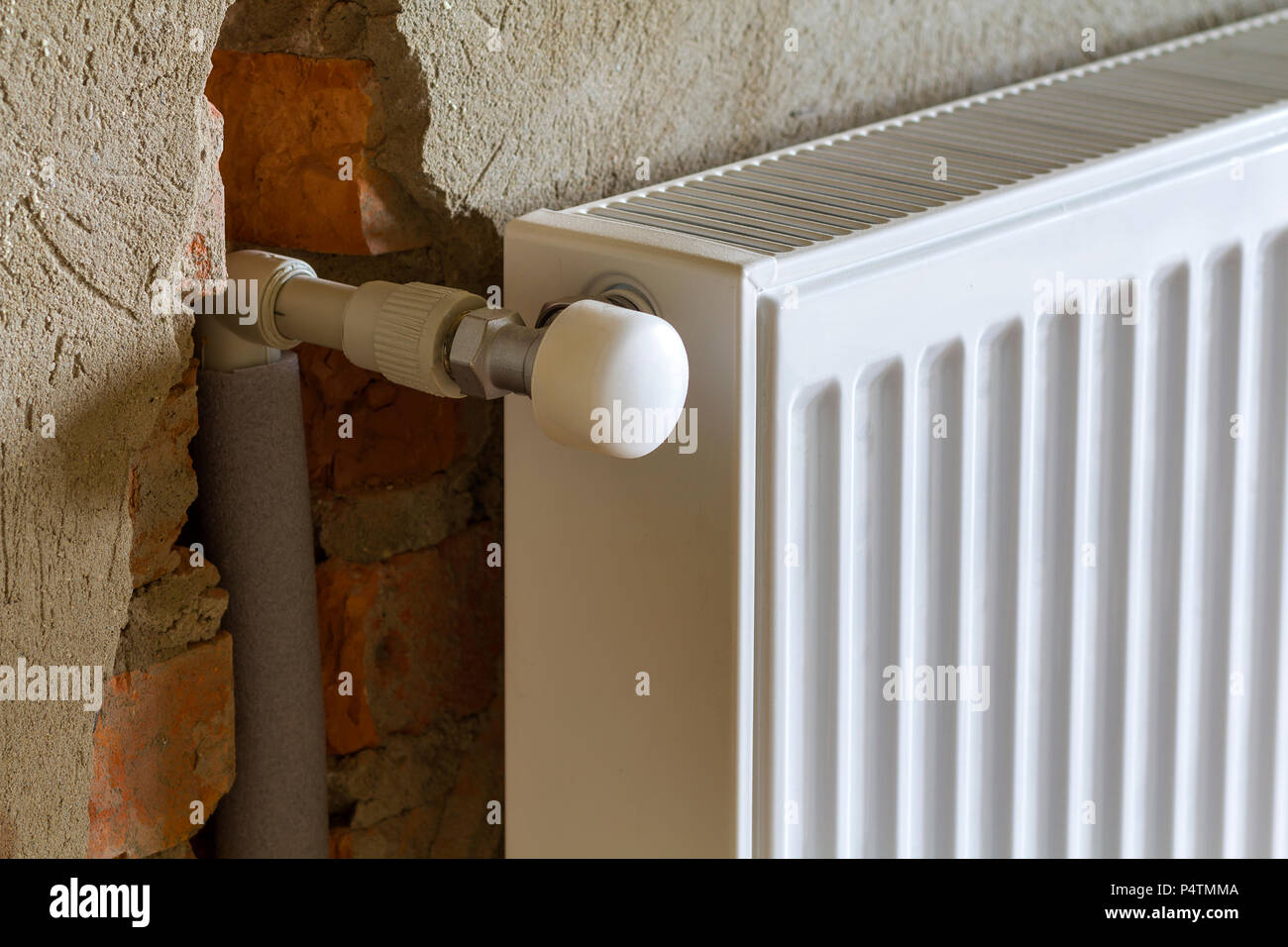 Close-up side view of isolated installed heating radiator on brick ...