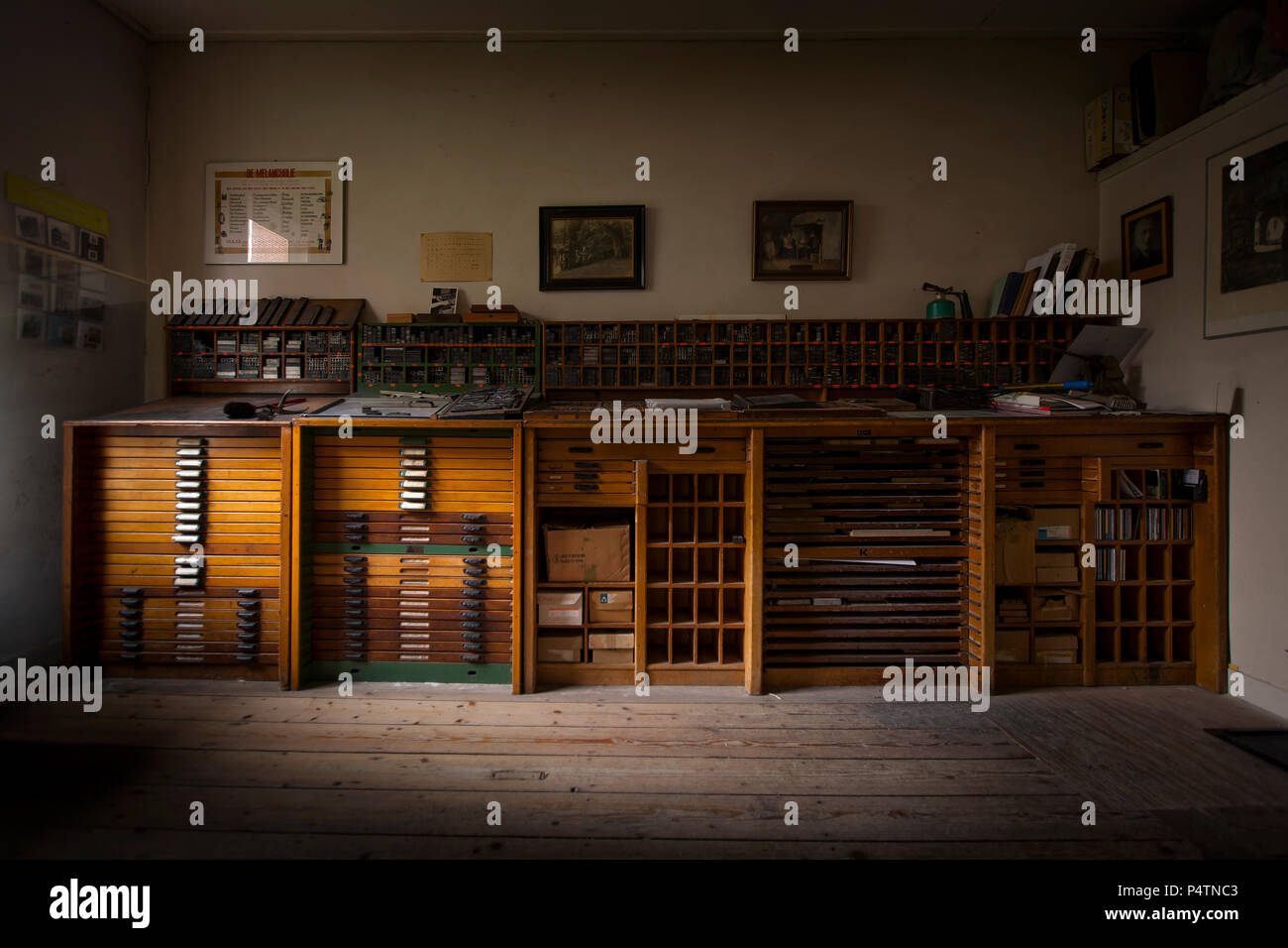 Type case in an old print office lit by one window, giving the scene a ...