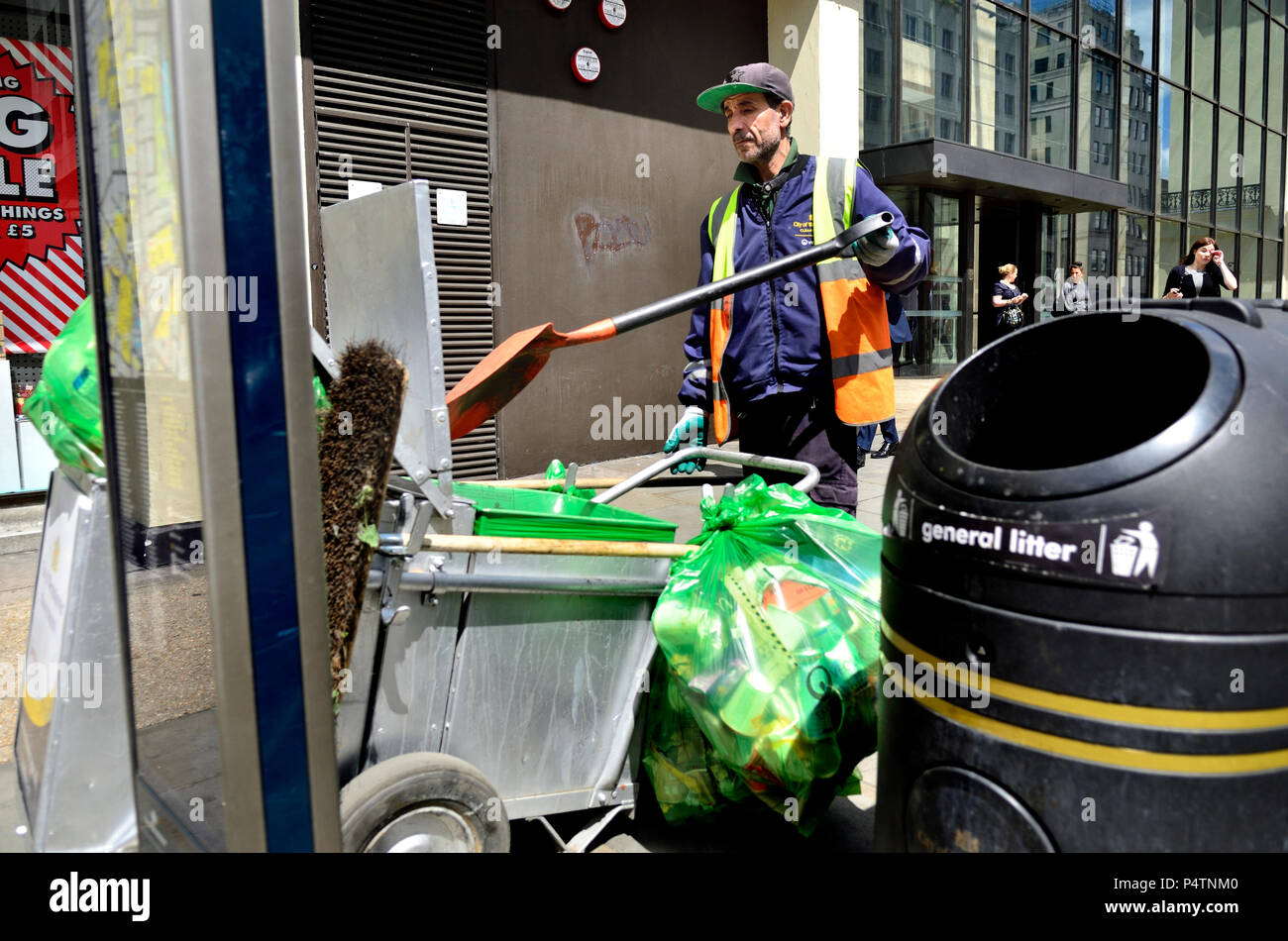 Street cleaner emptying rubbish bins in the Strand, central London ...