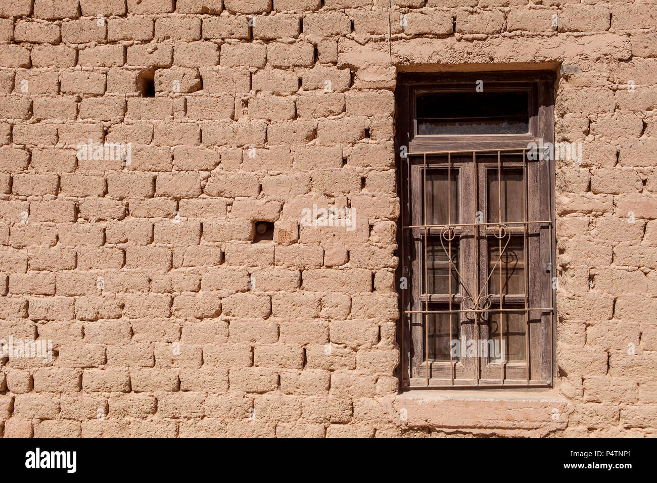 An adobe brick wall with a window Stock Photo - Alamy
