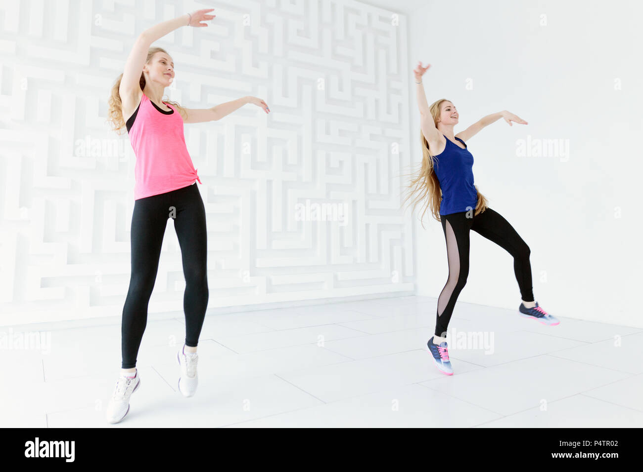 Group of two young fit women having fun while dancing at fitness dance ...