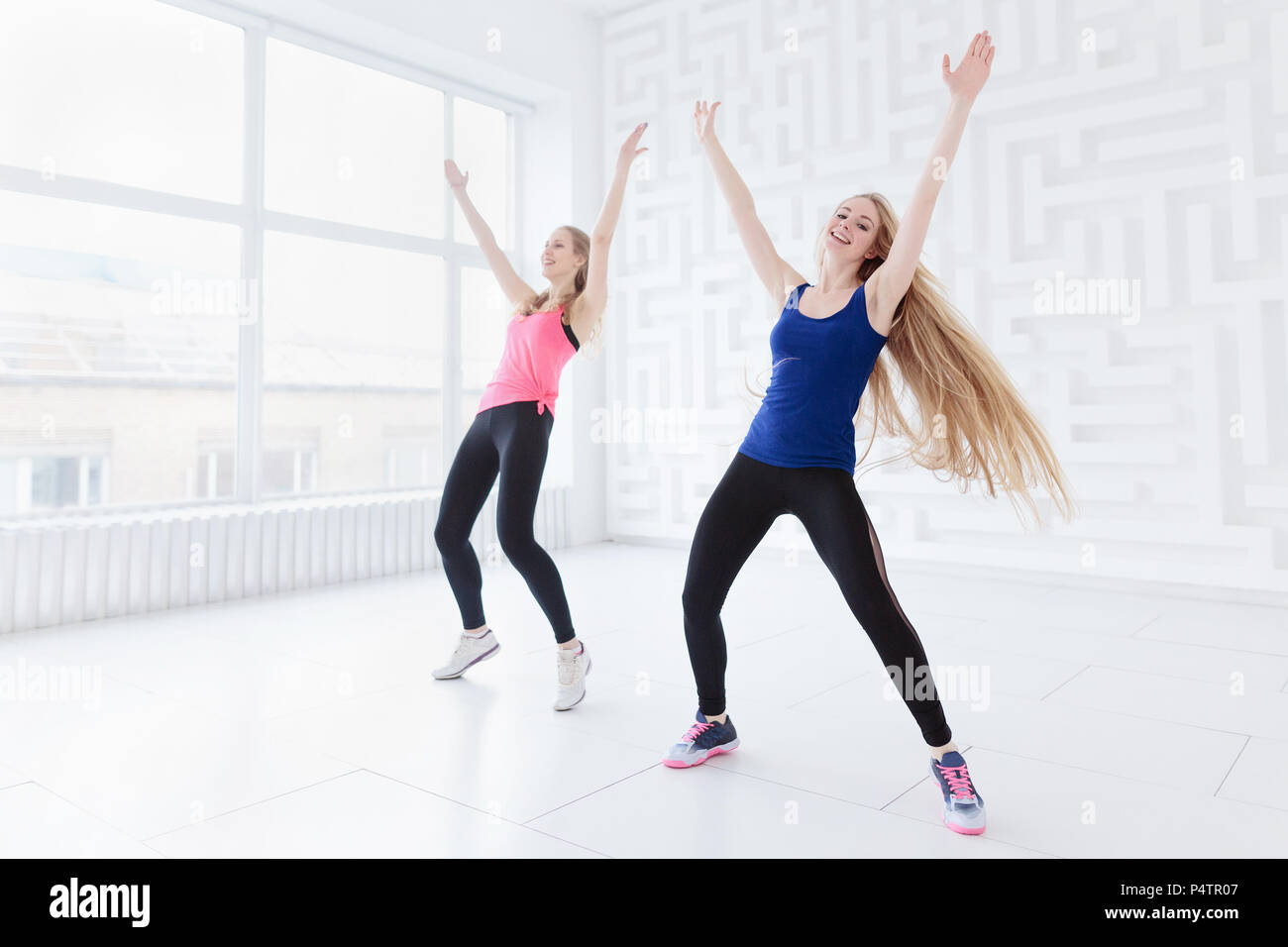 Fit young women doing a cardio exercises with hands raised up Stock ...