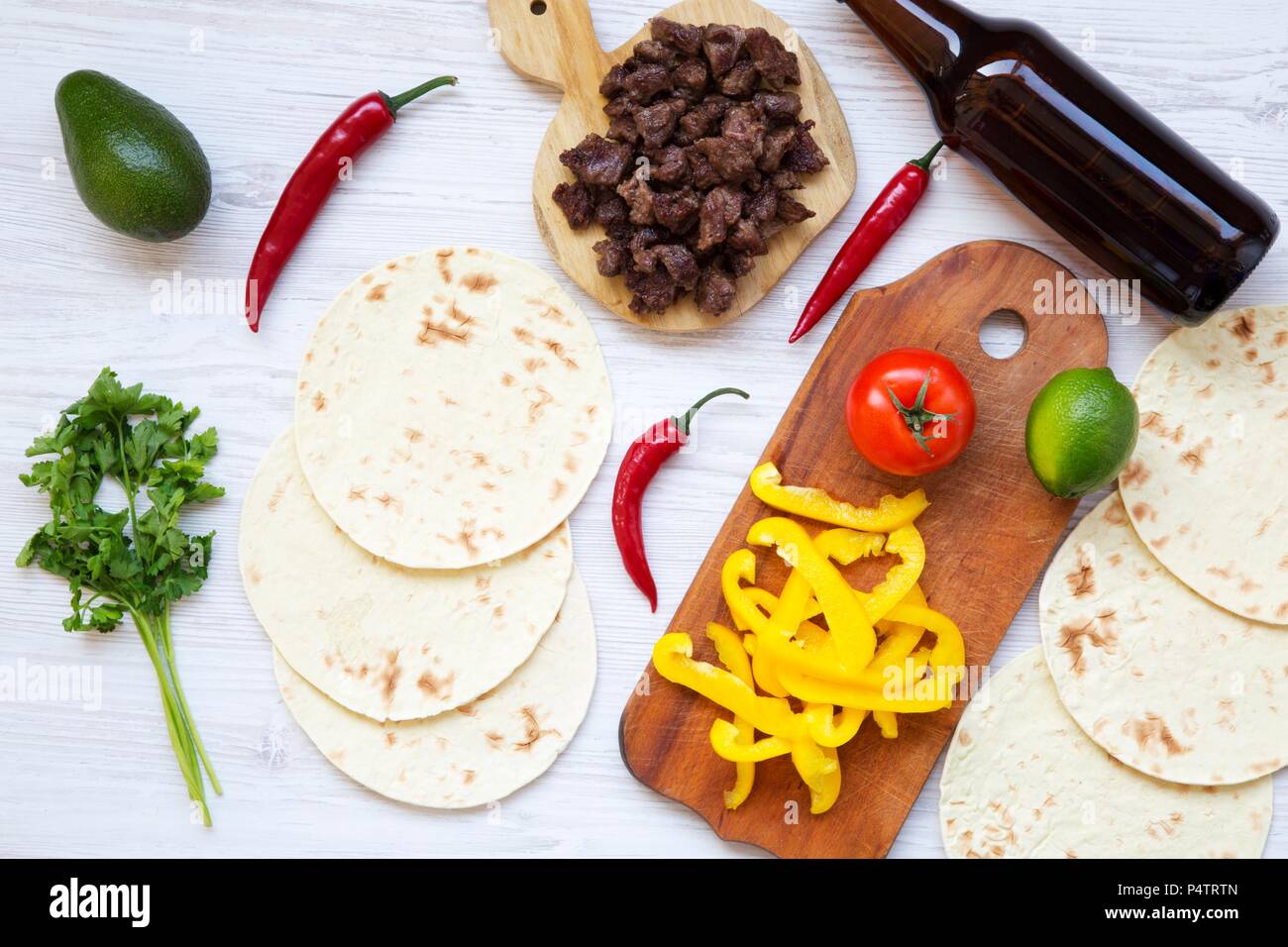 Tortillas on white wooden table. Ingredients for cooking tacos. Top ...