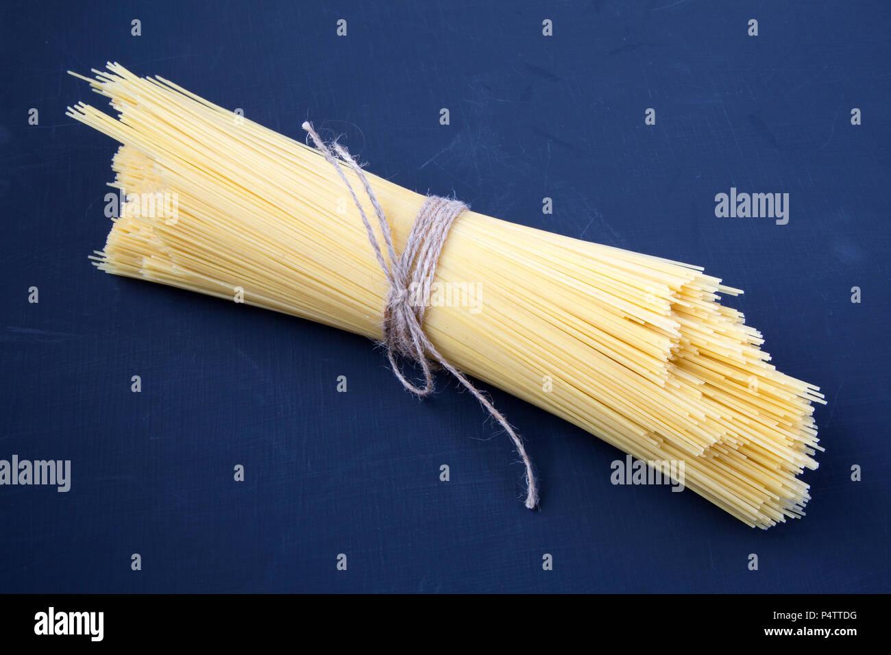 Spaghetti on dark background. Long spaghetti. Raw spaghetti. Side view ...