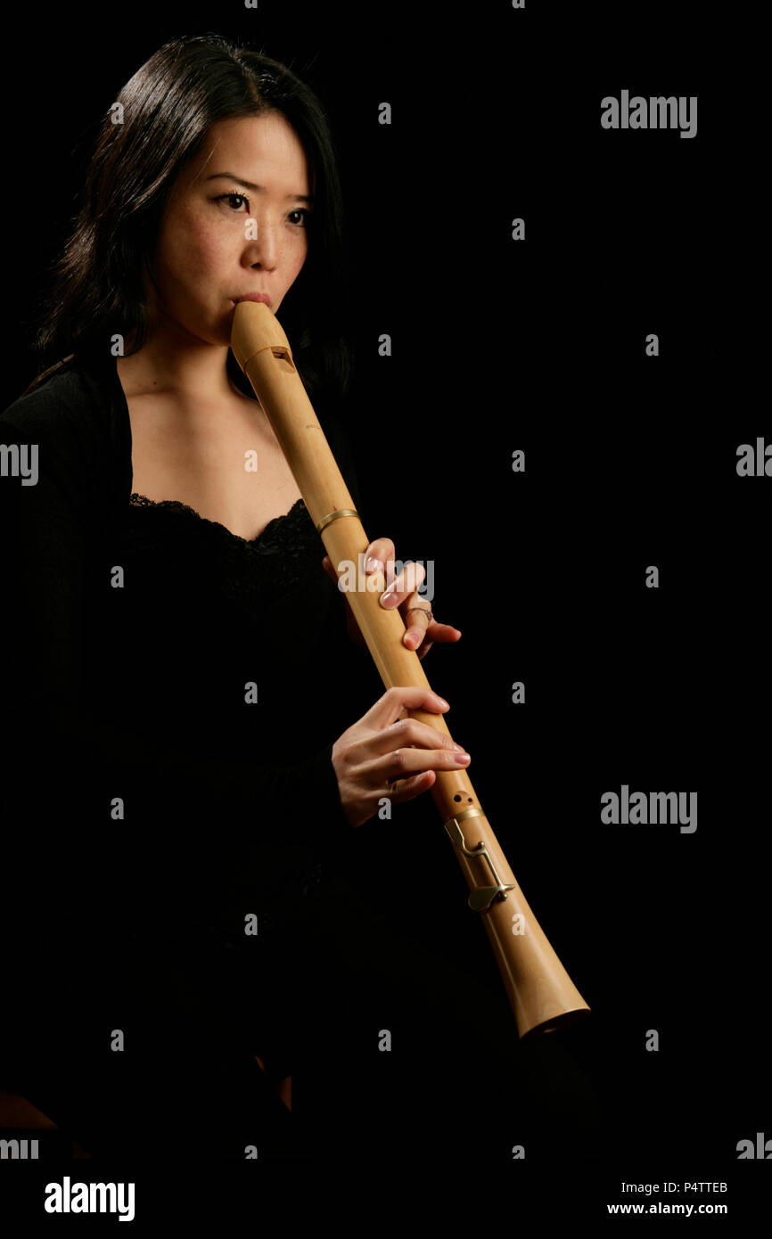 Oriental woman playing the tenor recorder Stock Photo - Alamy