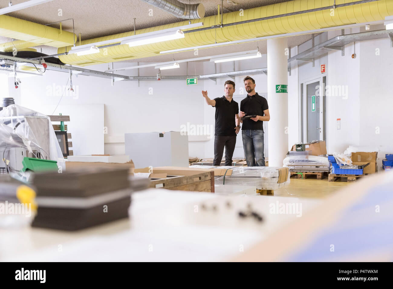 Two men talking in factory Stock Photo - Alamy