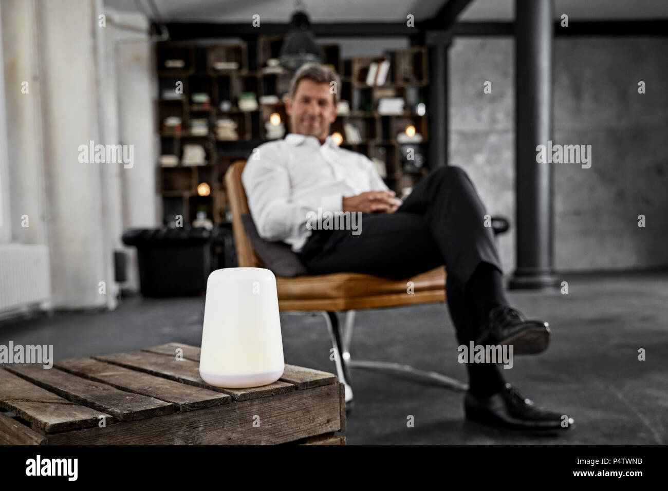 Mature man using voice-controlled digital assistant in loft Stock Photo ...