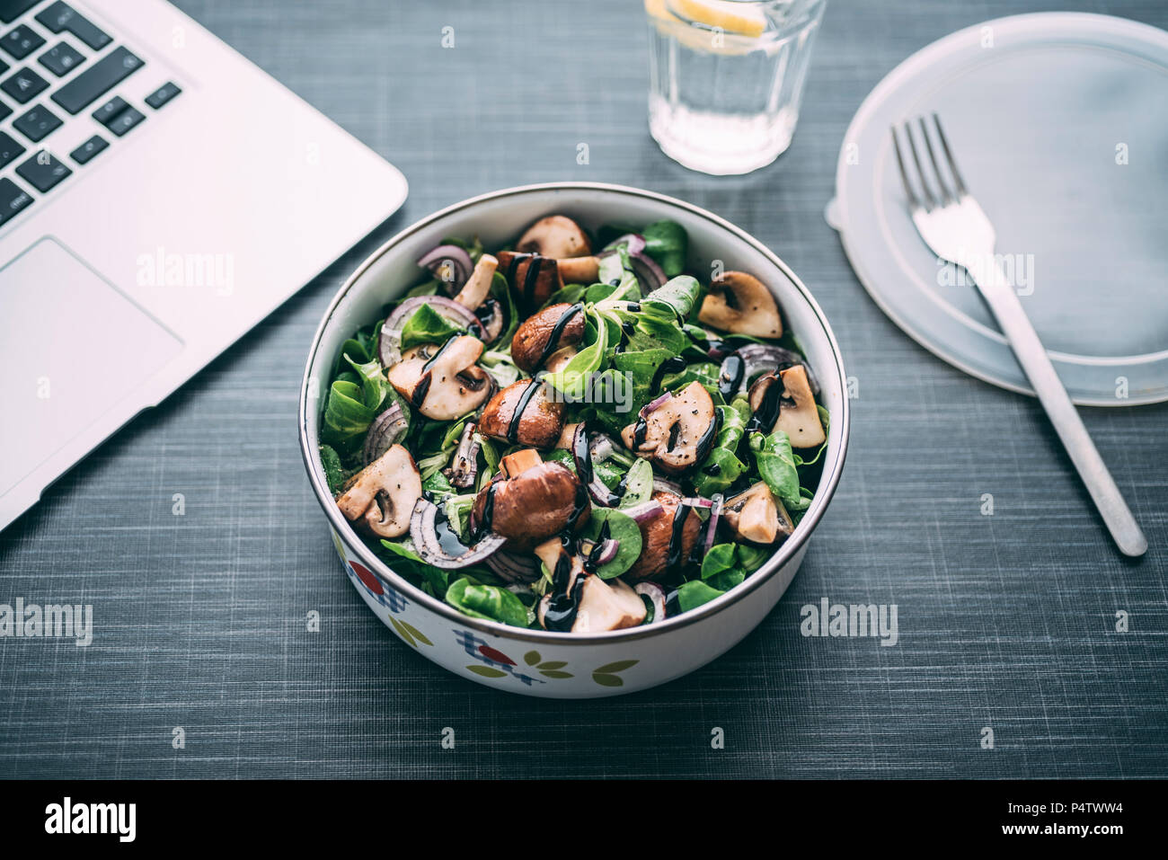 Lunch box with field salad, onions, roasted mushrooms, onions and ...