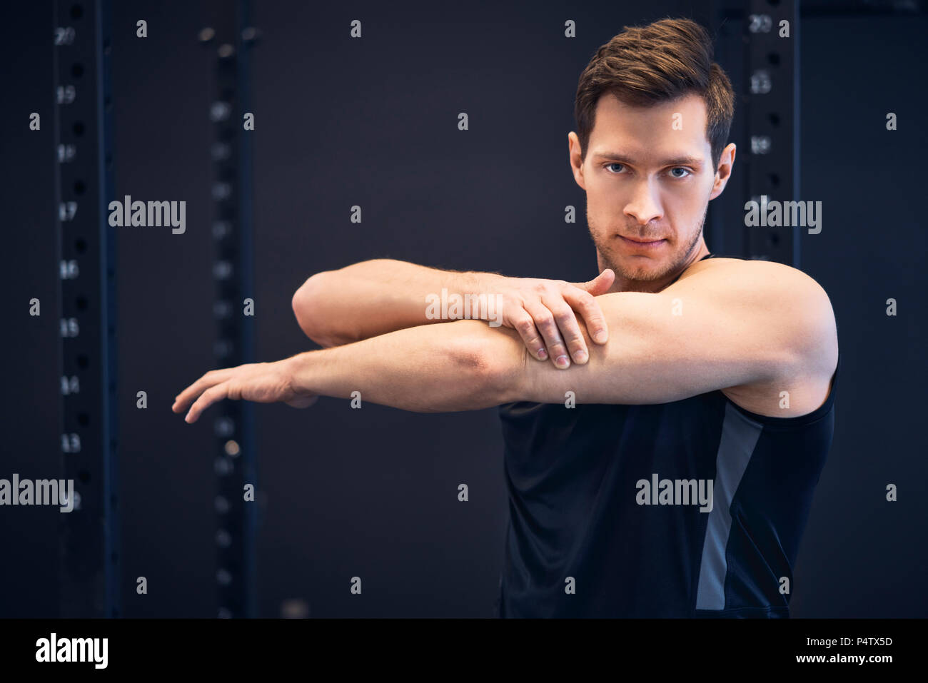 Athletic man stretching arms after gym workout Stock Photo - Alamy