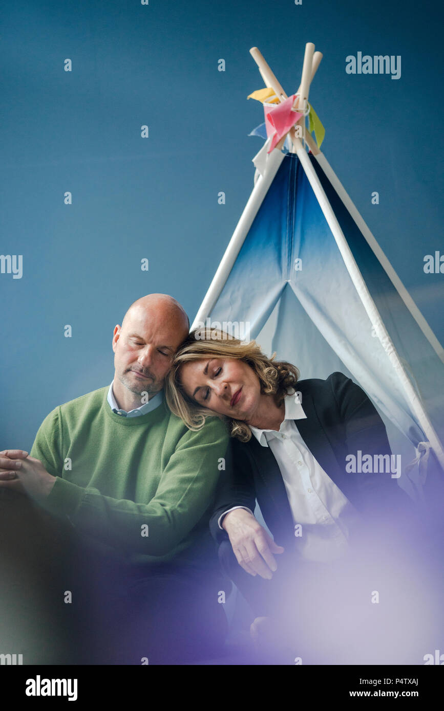 Tired couple sleeping at teepee indoors Stock Photo - Alamy