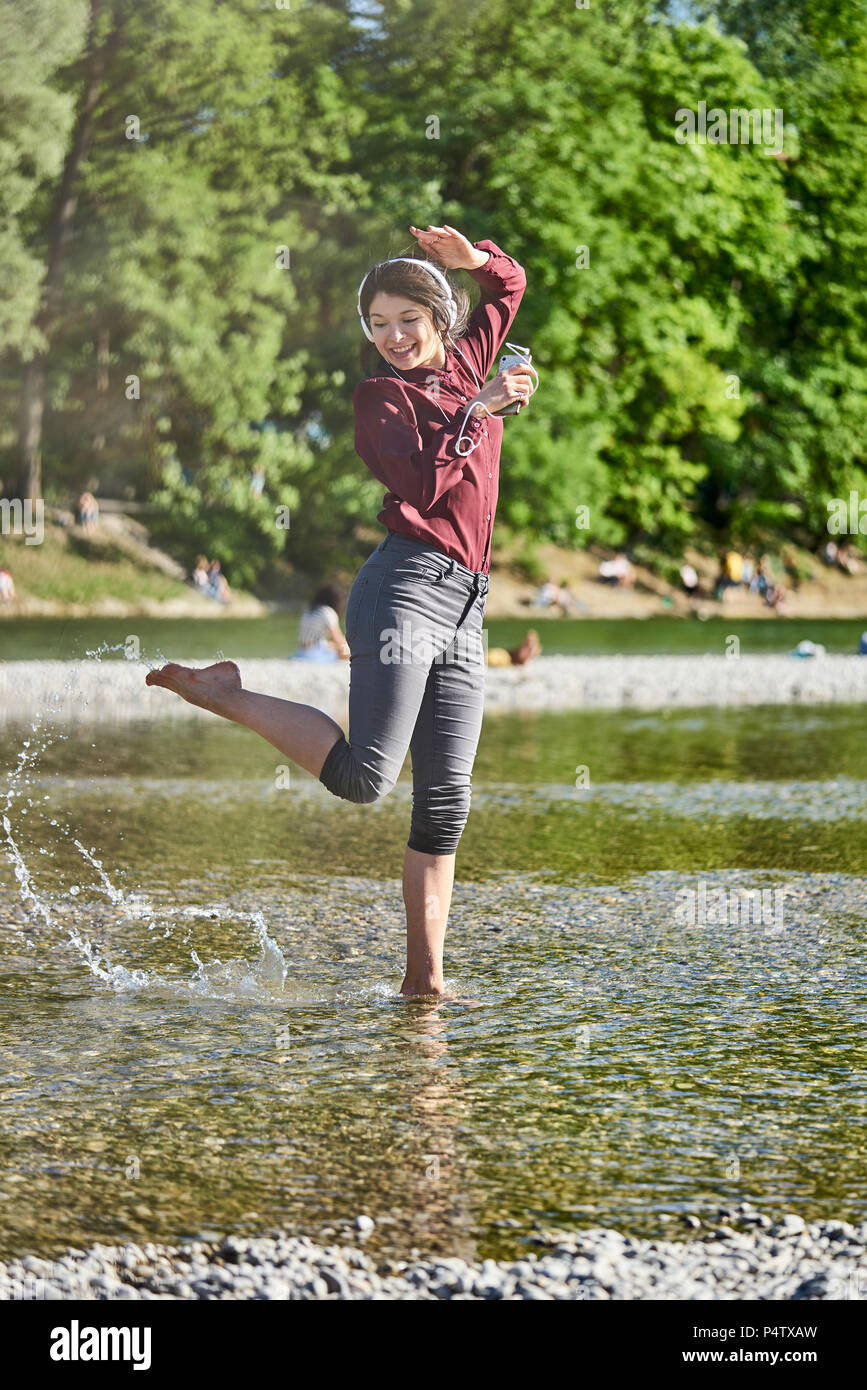 Happy young woman listening music with headphones and cell phone ...