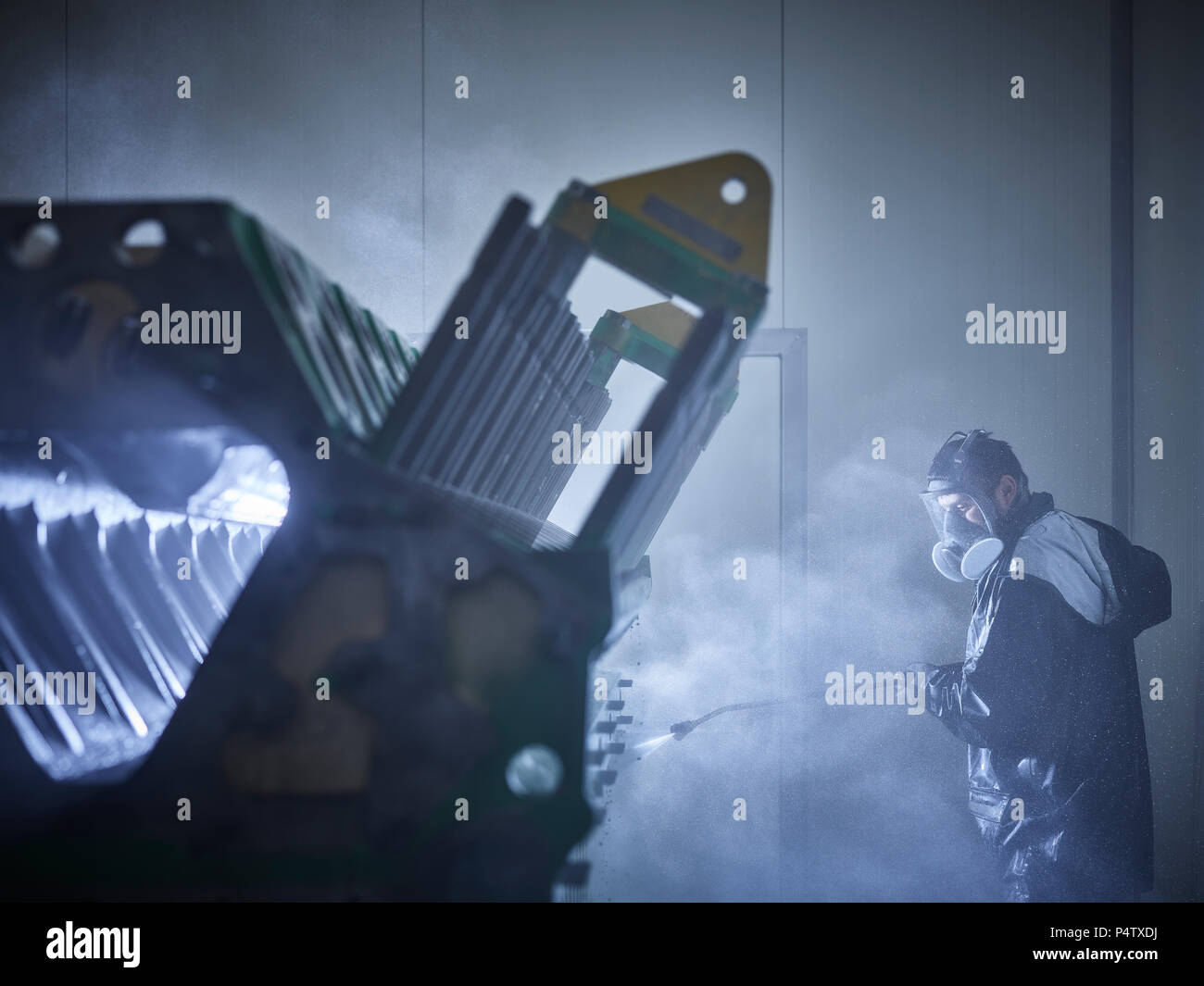 Worker cleaning engine block in washing bay Stock Photo - Alamy