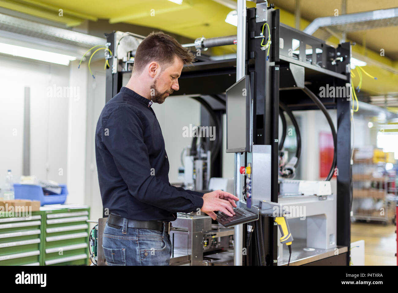 Man in factory operating machine Stock Photo - Alamy