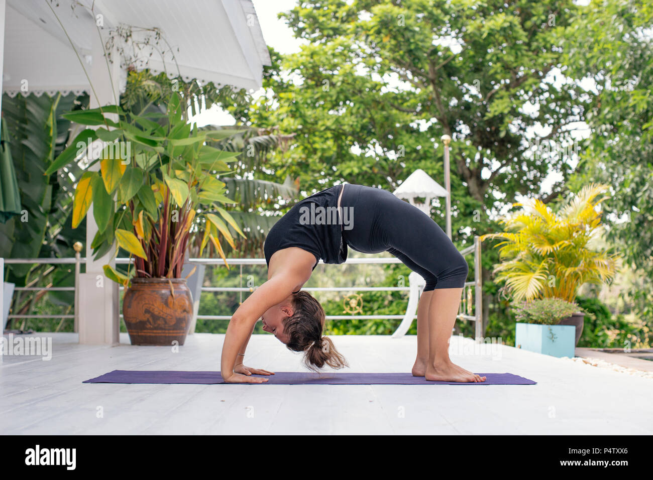 Woman practicing yoga on terrace Stock Photo - Alamy