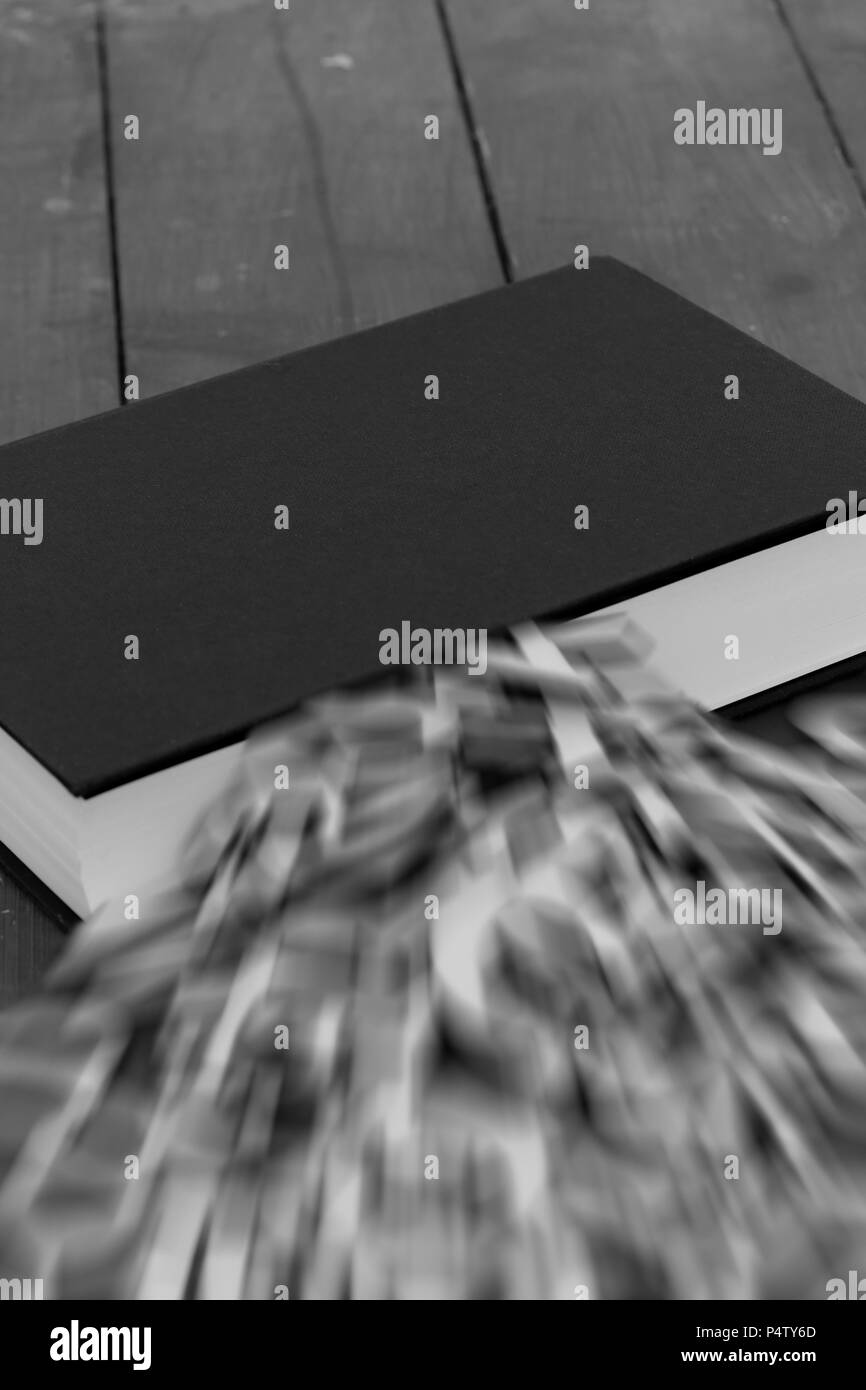 Book with blurred letters coming out of the pages on a wood background ...