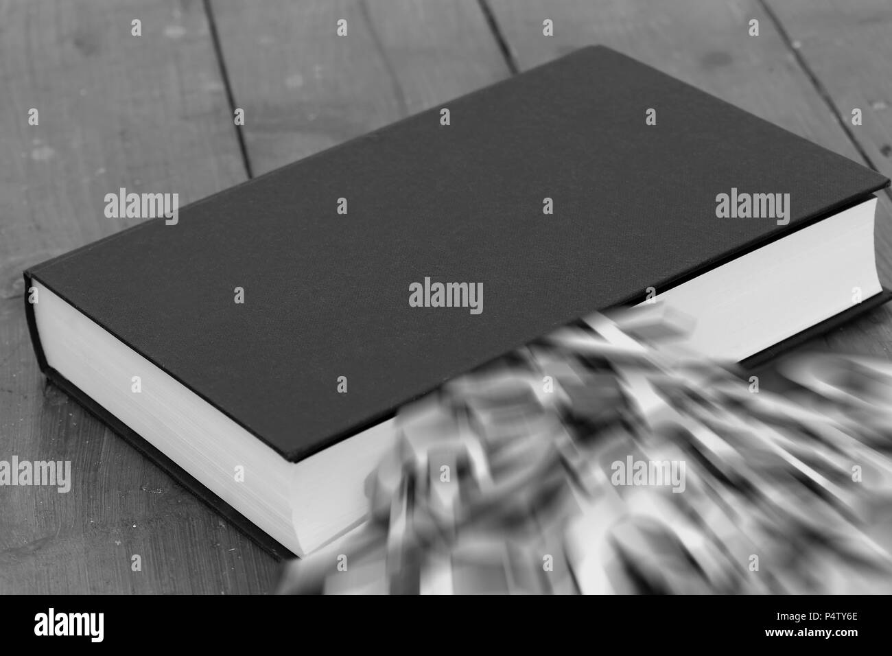 Book with blurred letters coming out of the pages on a wood background ...