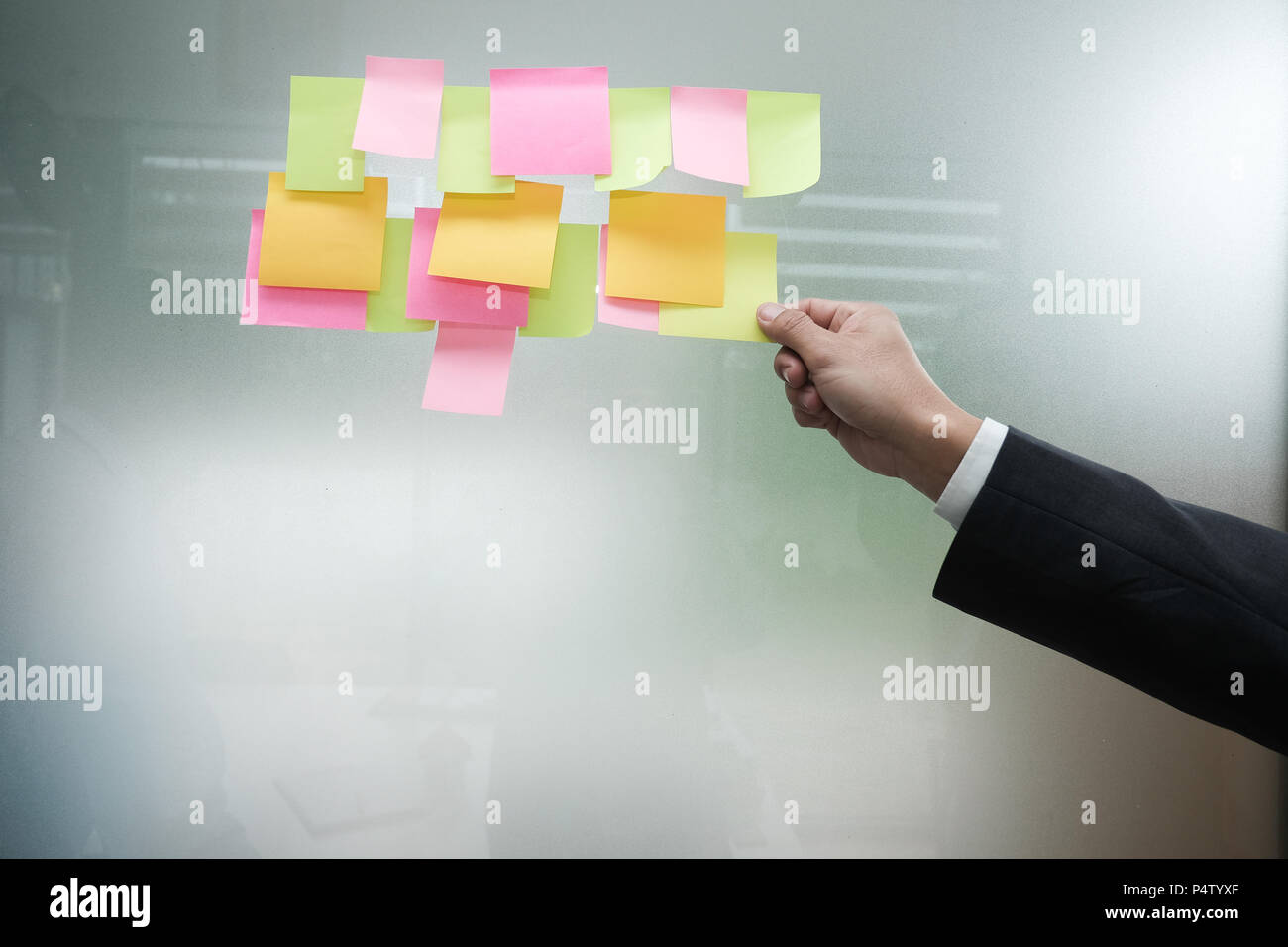 Businessman hold adhesive notes on glass wall at workplace. Sticky note ...