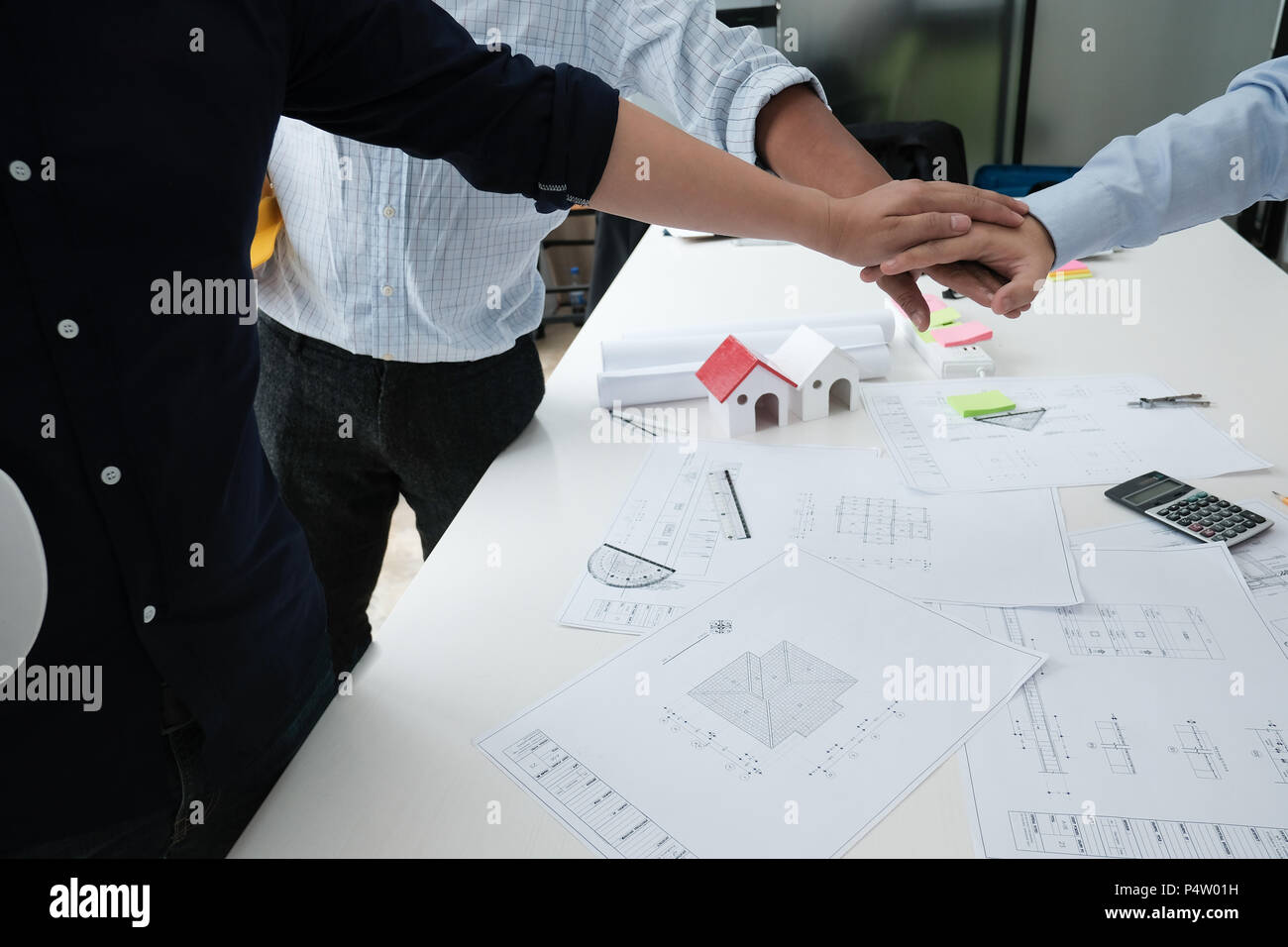 architect & customer joining hands at workplace. Engineer put hand ...