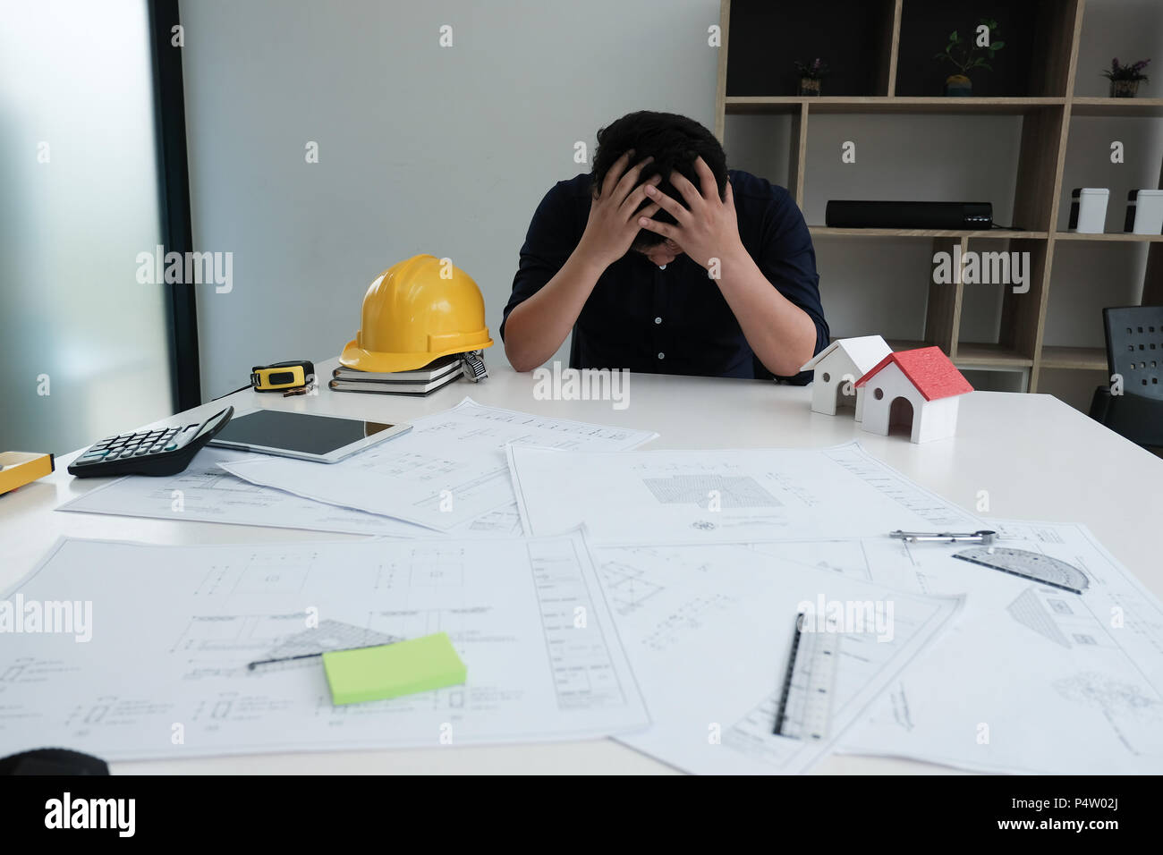 stressful engineer man put hand on head. exhausted architect is tired ...