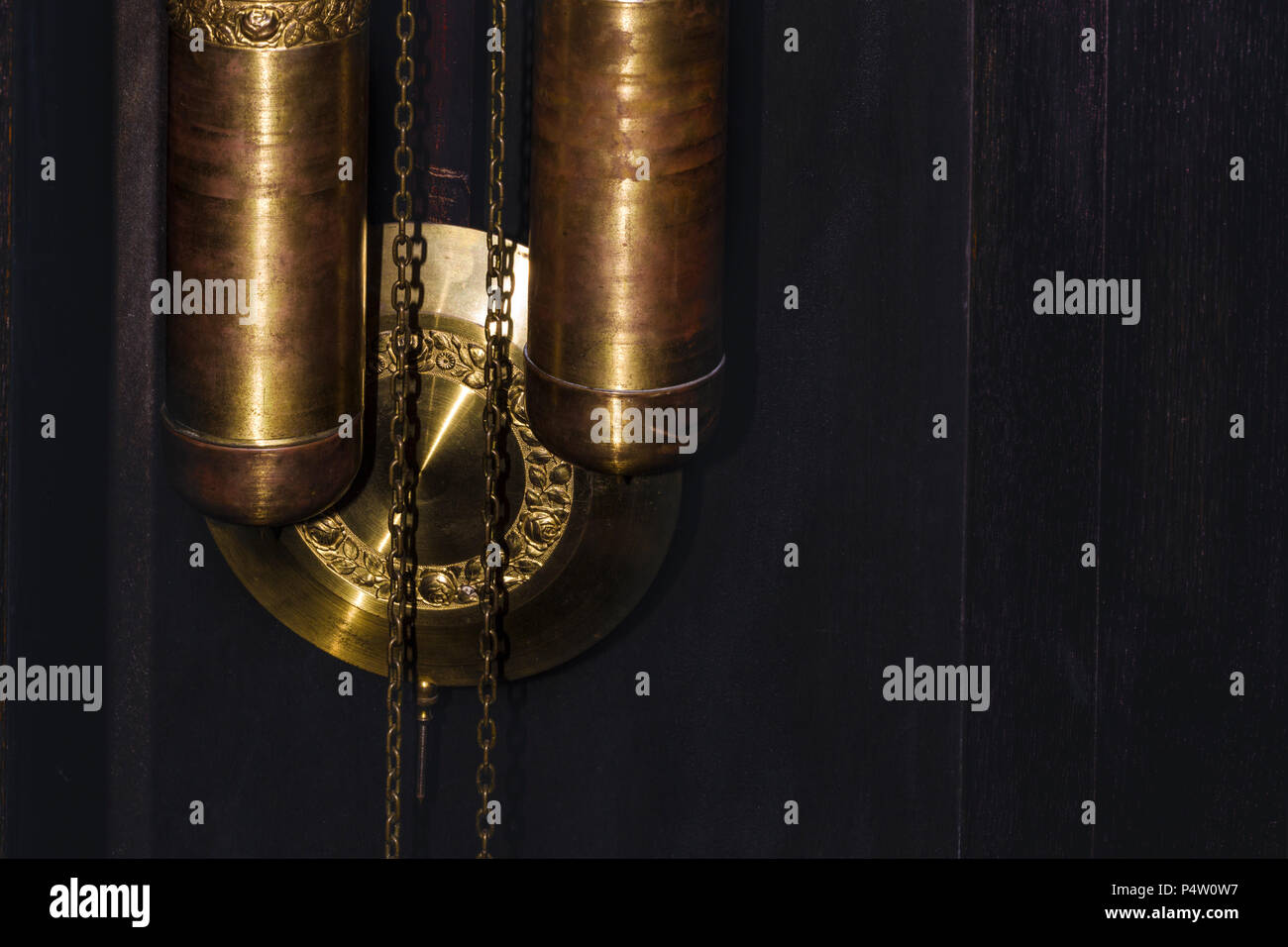 golden pendulum from the clock close-up on a dark background with space ...