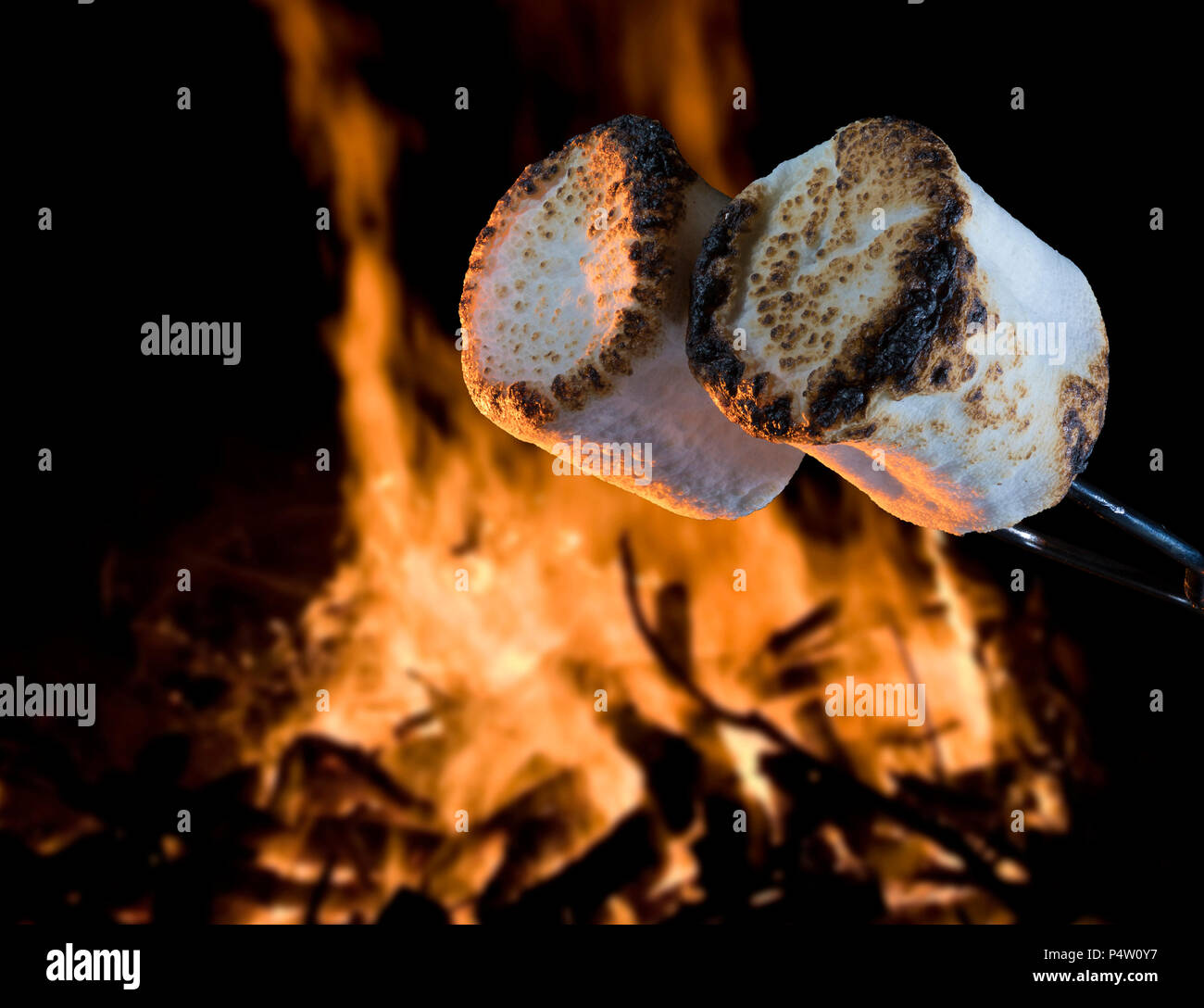 Two marshmallows being roasted over a campfire to make smores Stock ...