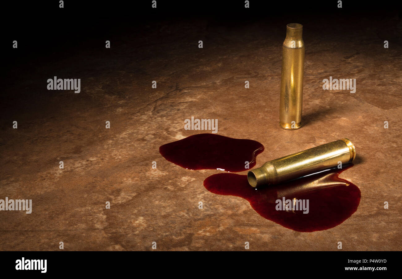 Blood around a pair of empty assault rifle bullets on a beige floor ...