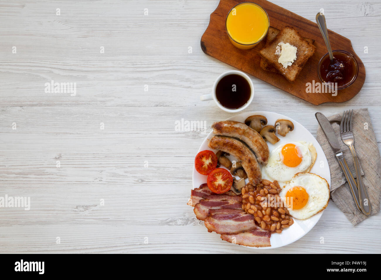 Flat lay, full english breakfast with fried eggs, sausages, bacon ...