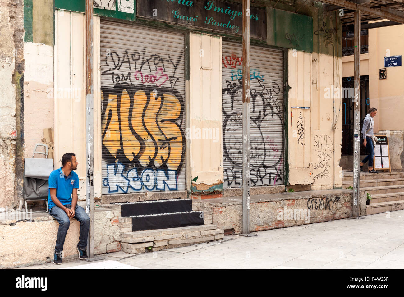 Valencia, Spain, man is sitting in front of locked roller blinds in ...