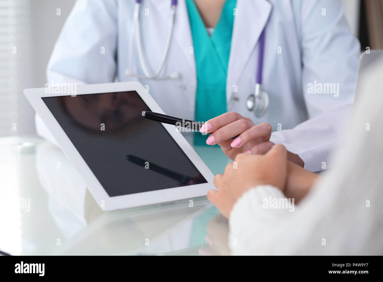 Doctor and patient, close-up. Physician pointing into laptop computer ...
