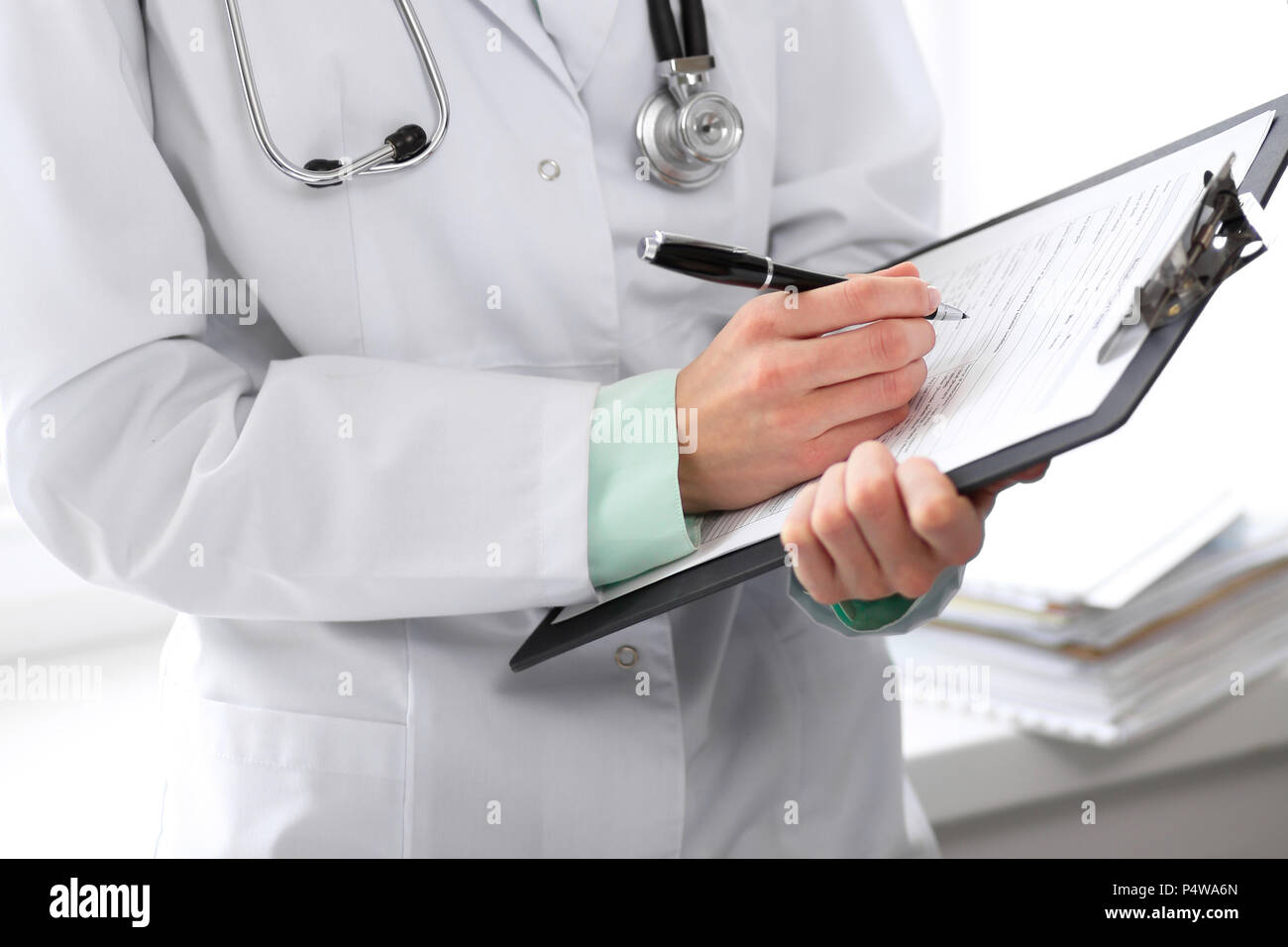 Female doctor filling up medical form on clipboard closeup. Healthcare ...